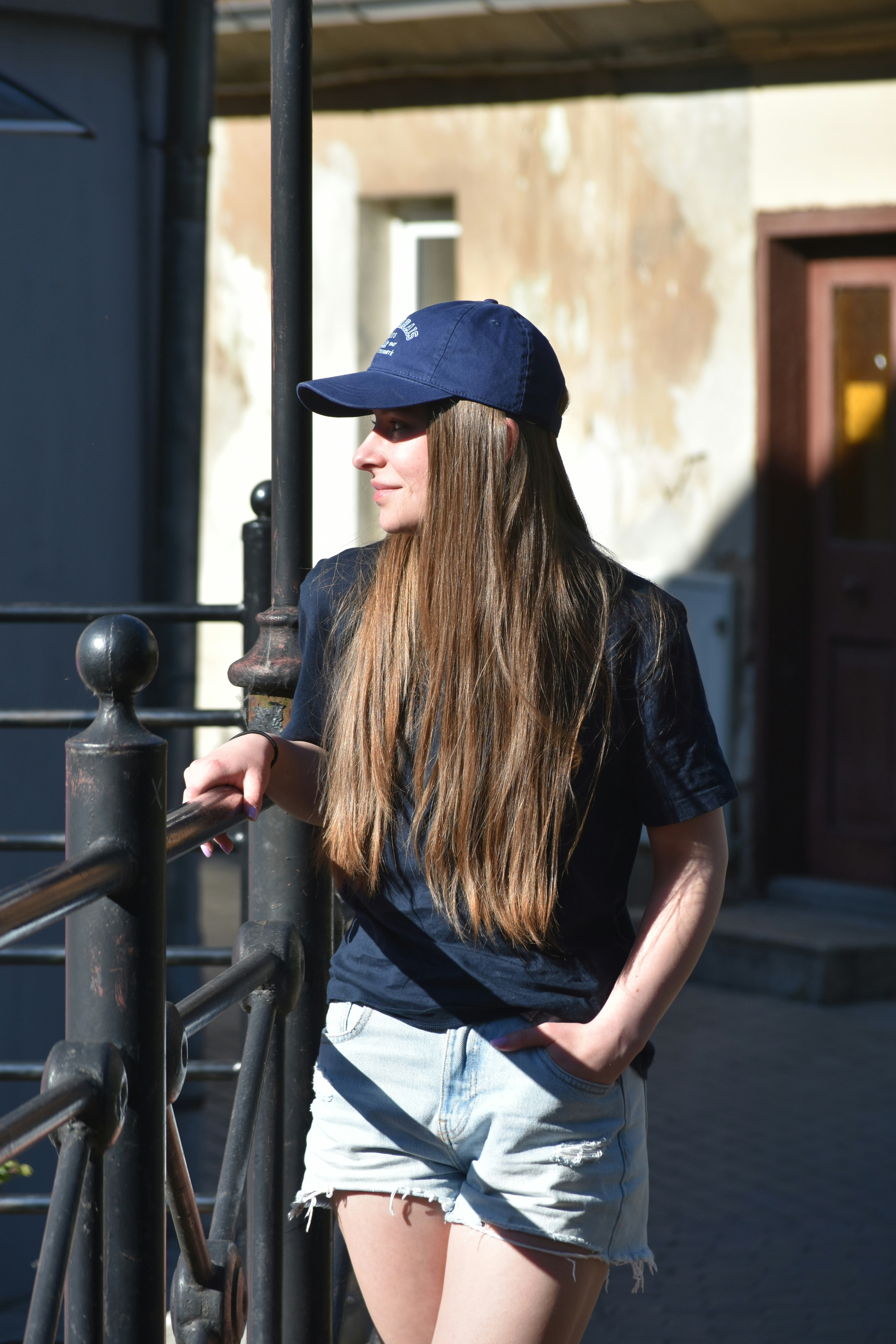Side-lit Portrait: Teen in a Blue Cap by a Rust-Colored Door