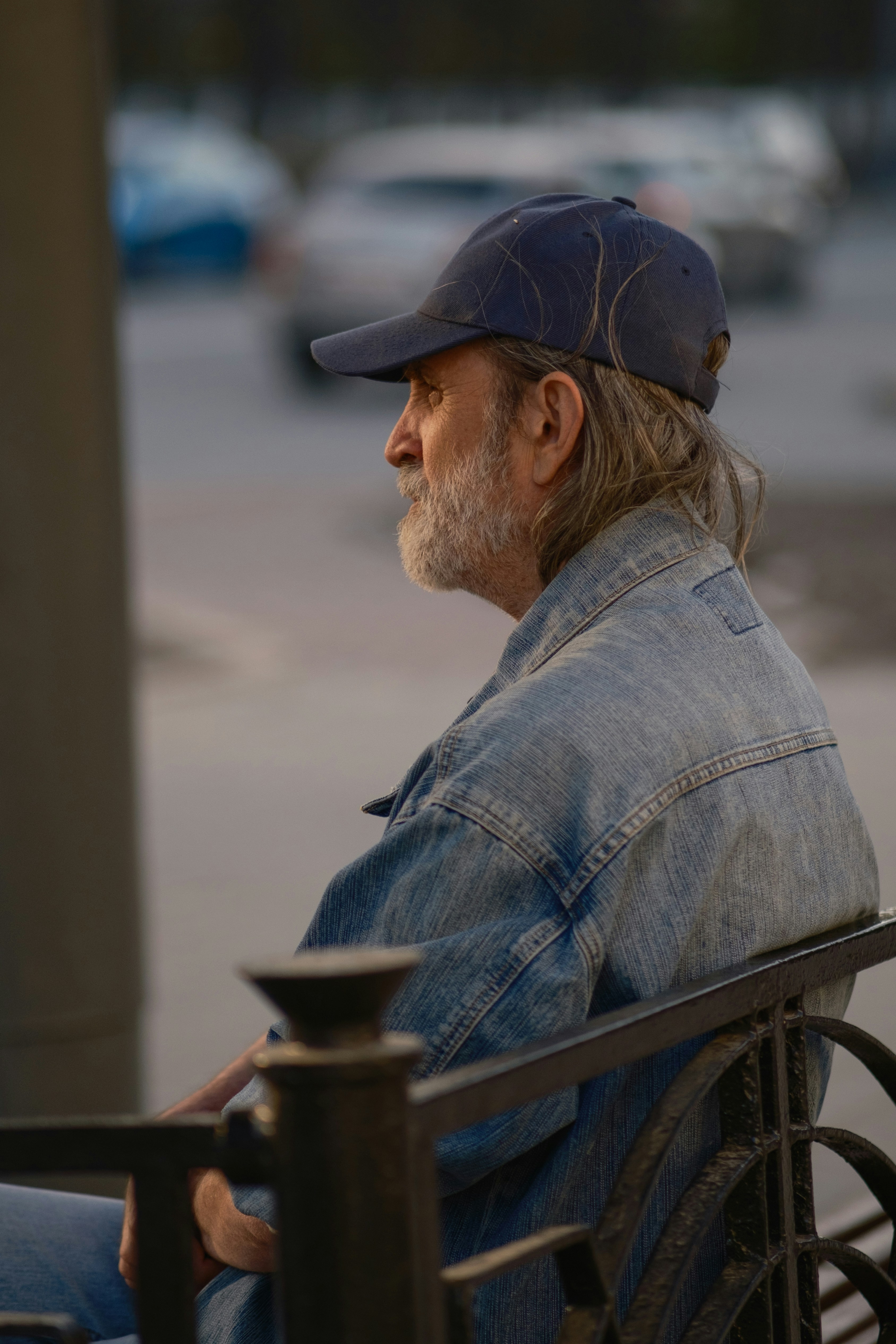 Portrait on a Quiet Bench: Weathered Gaze and Denim in Soft Evening Light