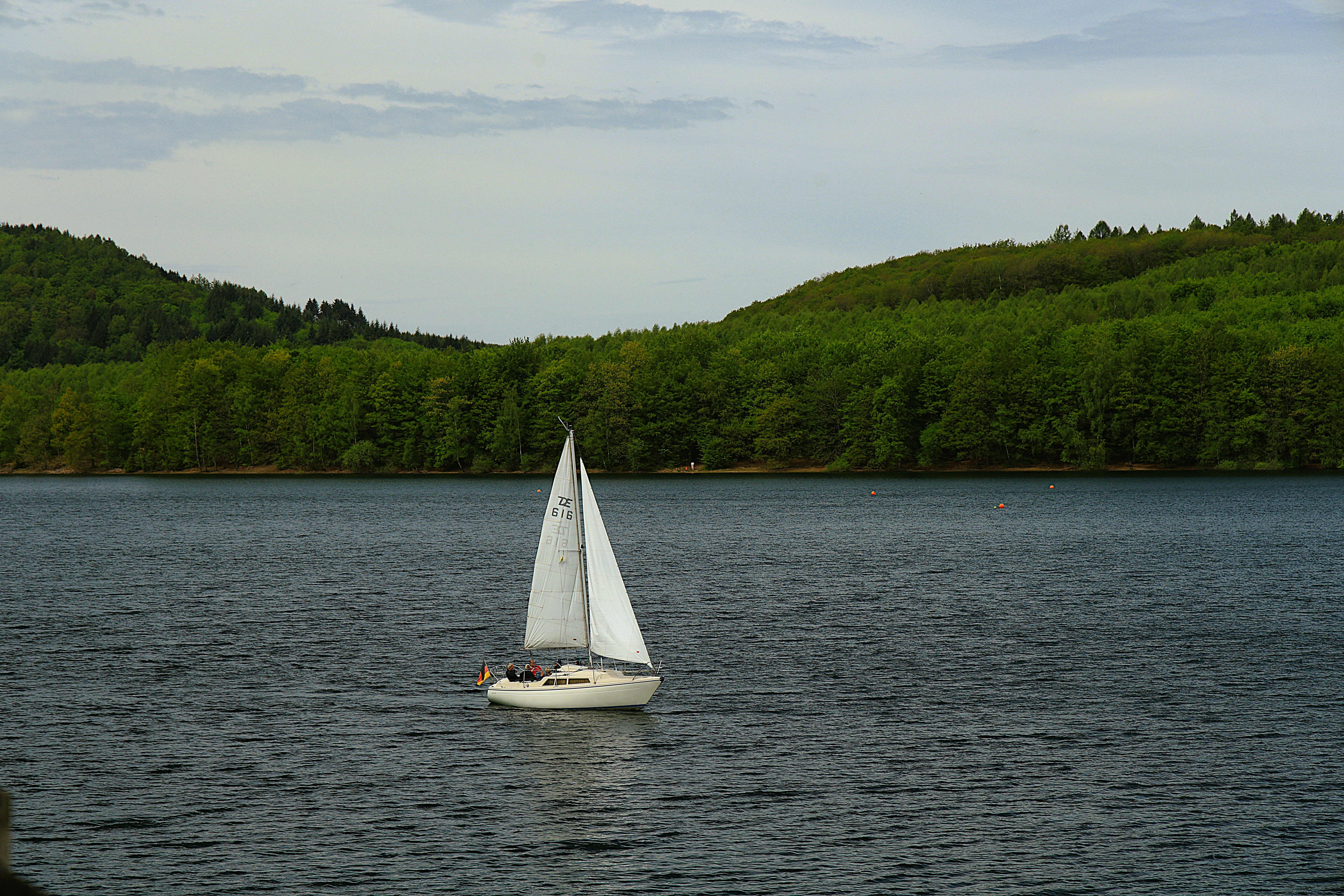 Sailboat Drifting Across a Quiet Lake at Dusk