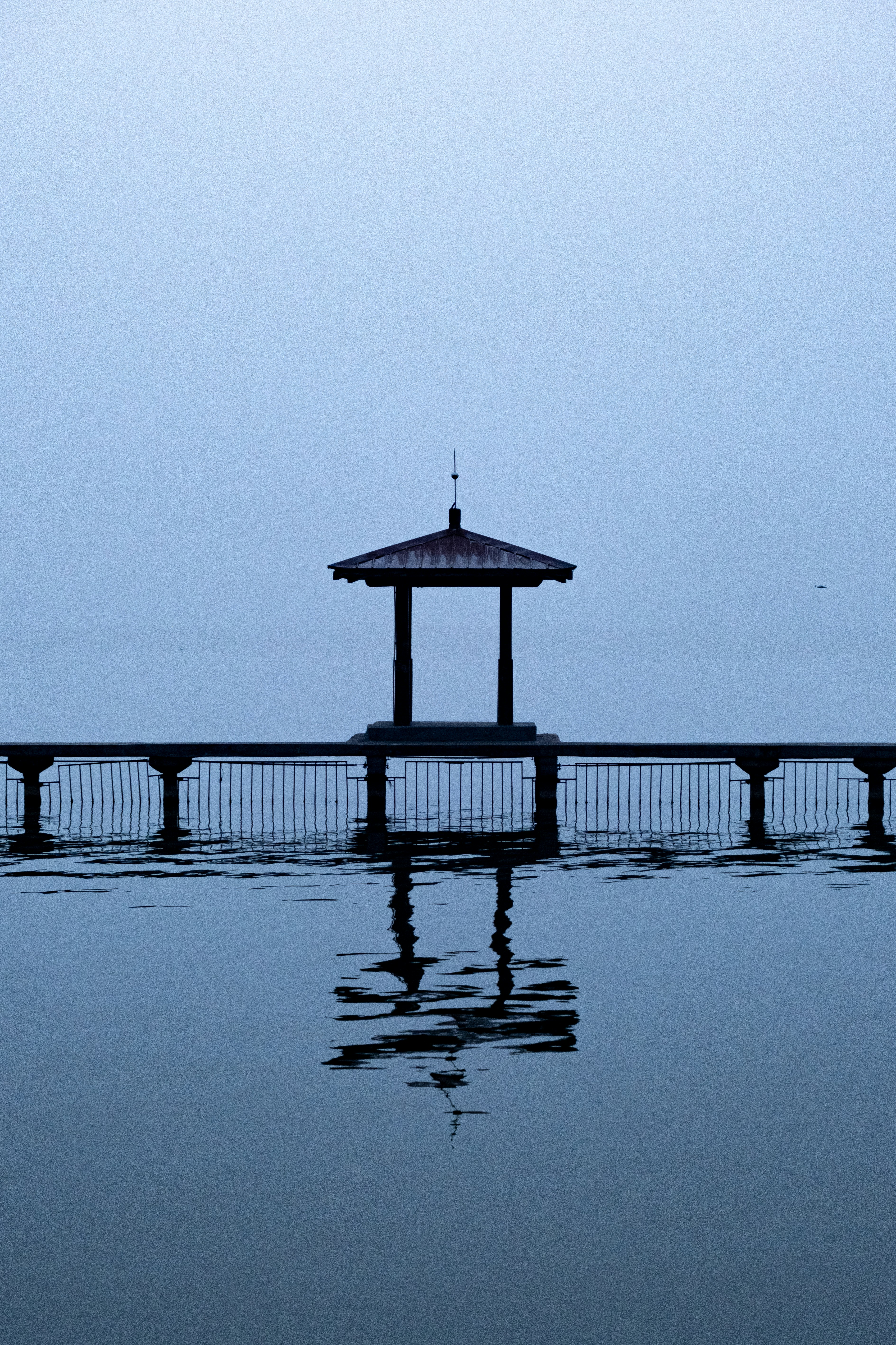 Pier Lantern at Dusk: A Silhouette over Tranquil Water