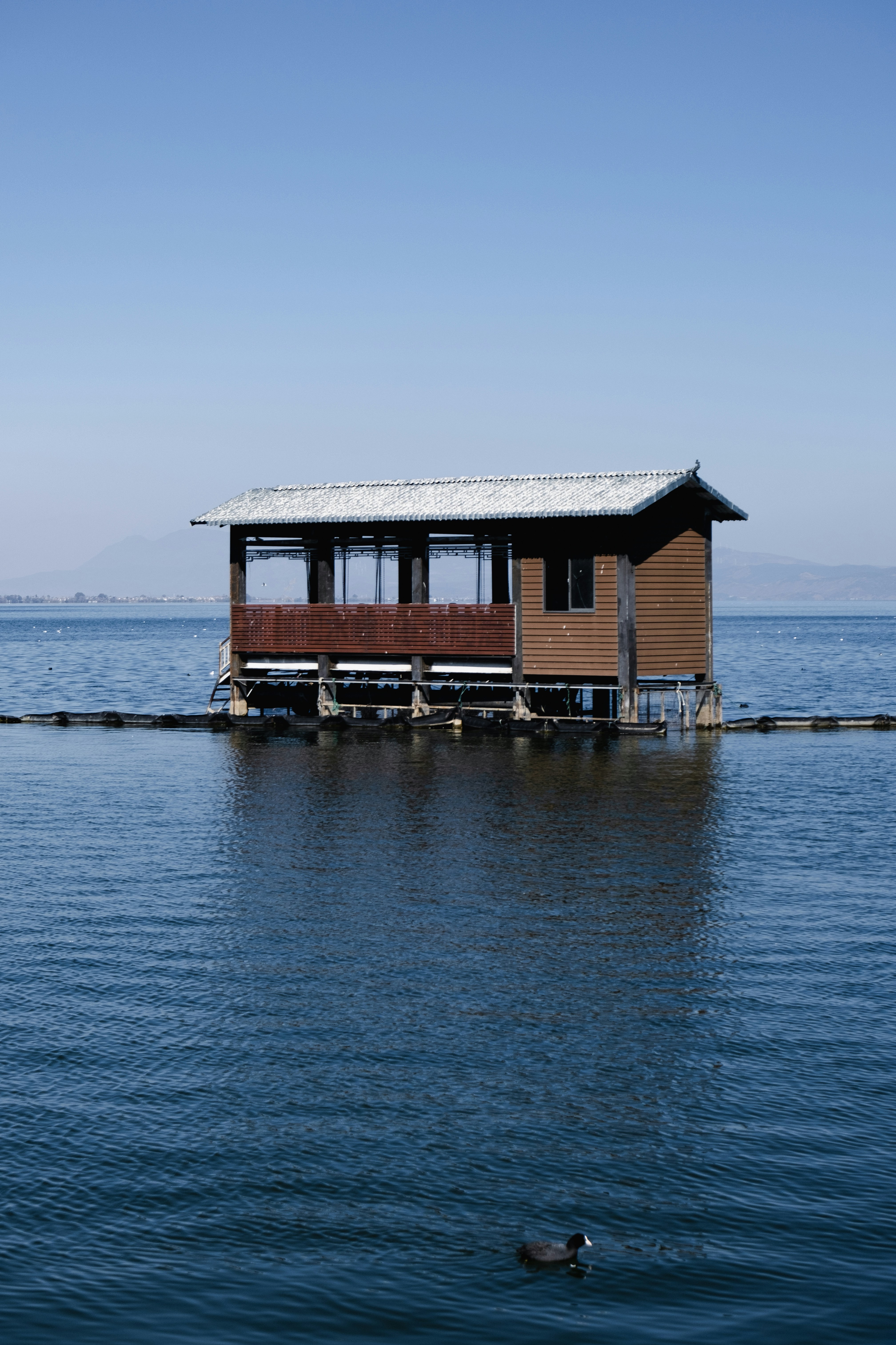 Horizon House: A lone pier-side hut over calm blue water