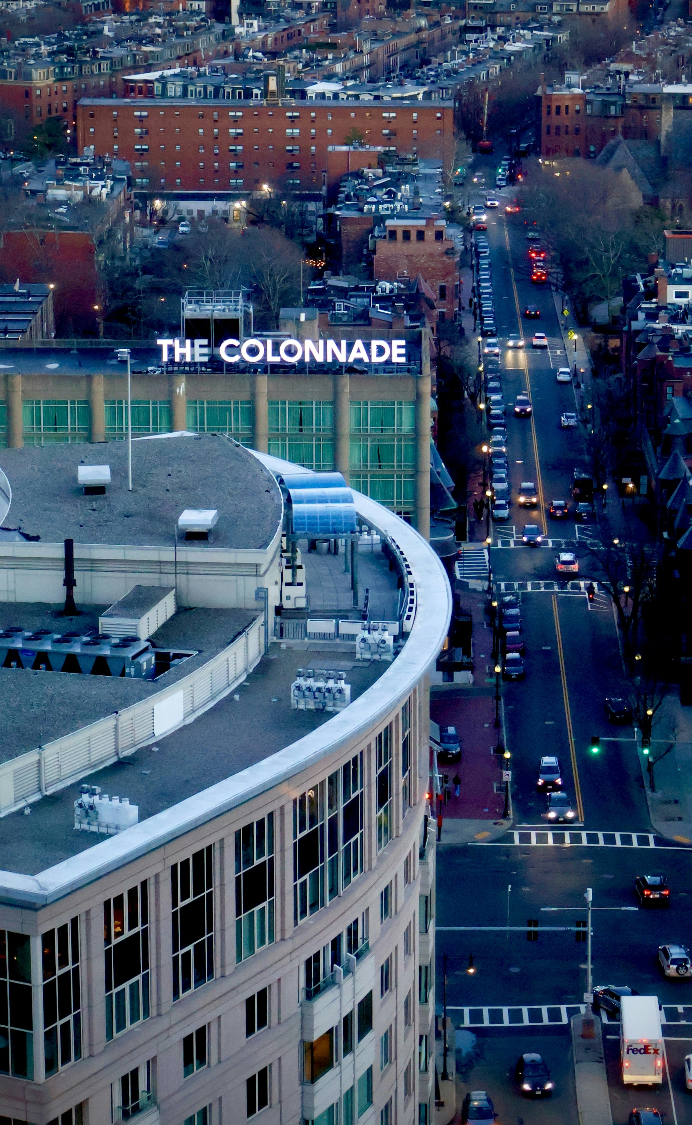 The Colonnade Clock Denizen: A bird’s-eye view over a curved modern facade and city street