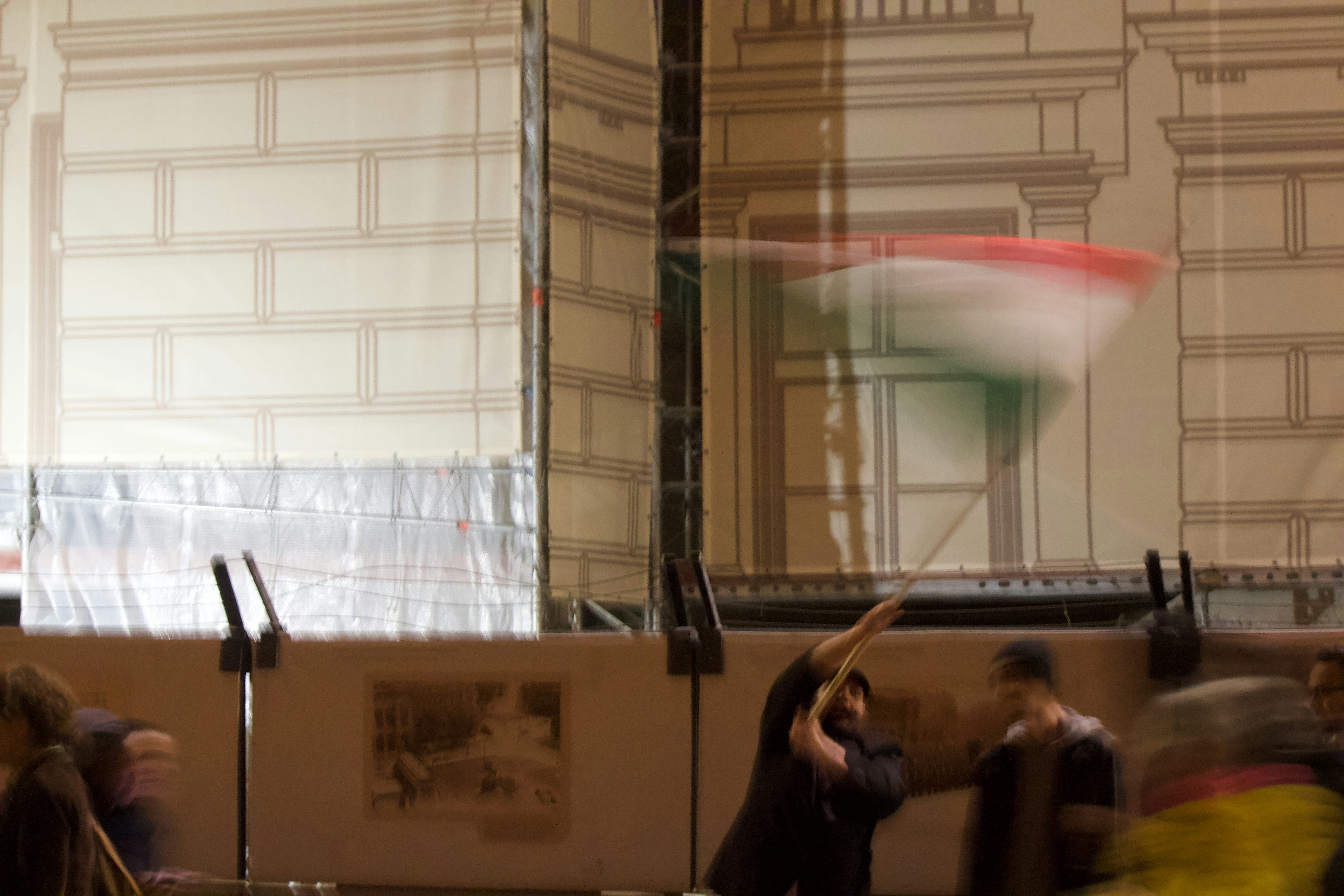 Flags in Motion: Blurred Crowd and City Panel
