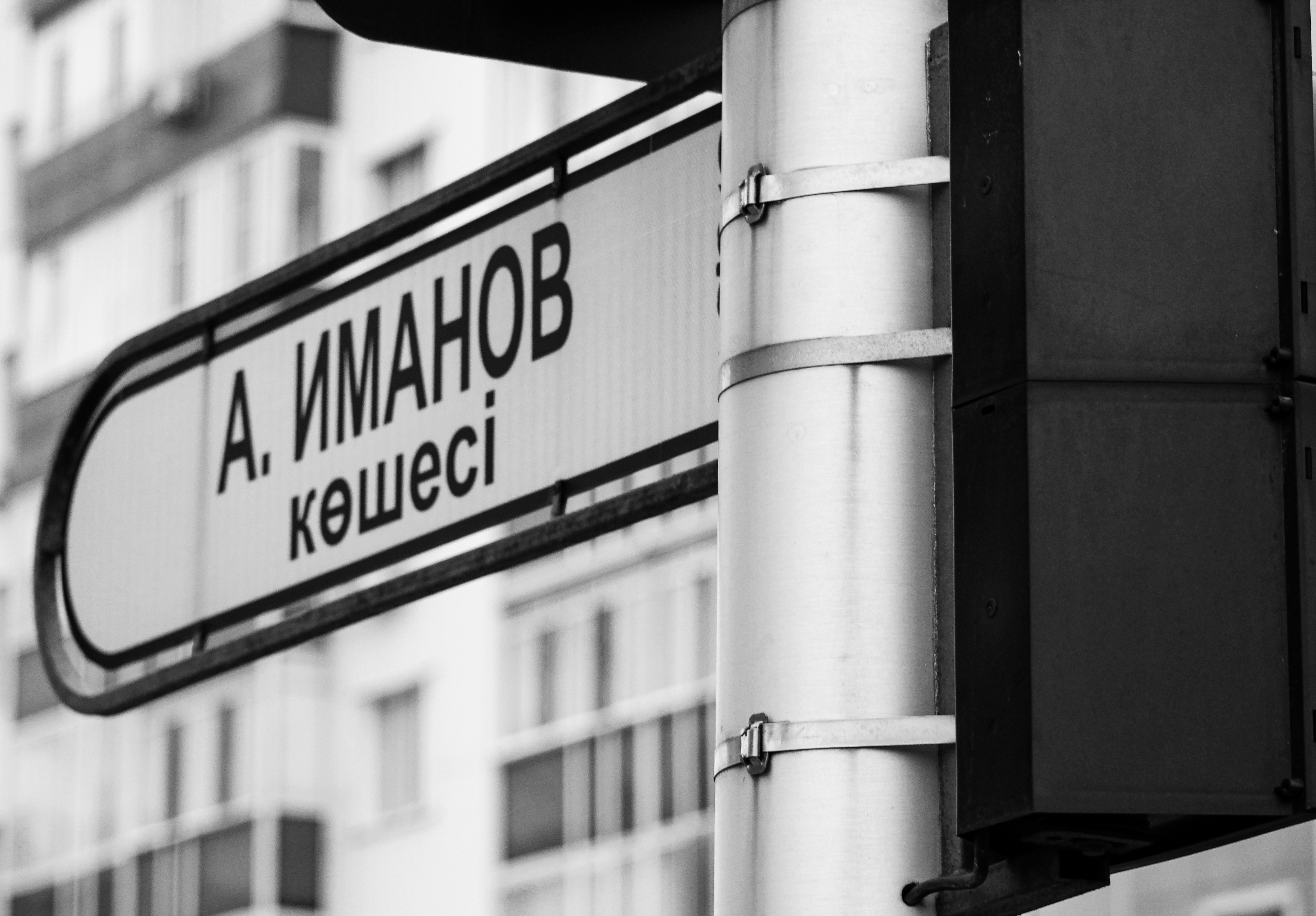 Curbside Cyrillic Street Sign in Moody Black-and-White