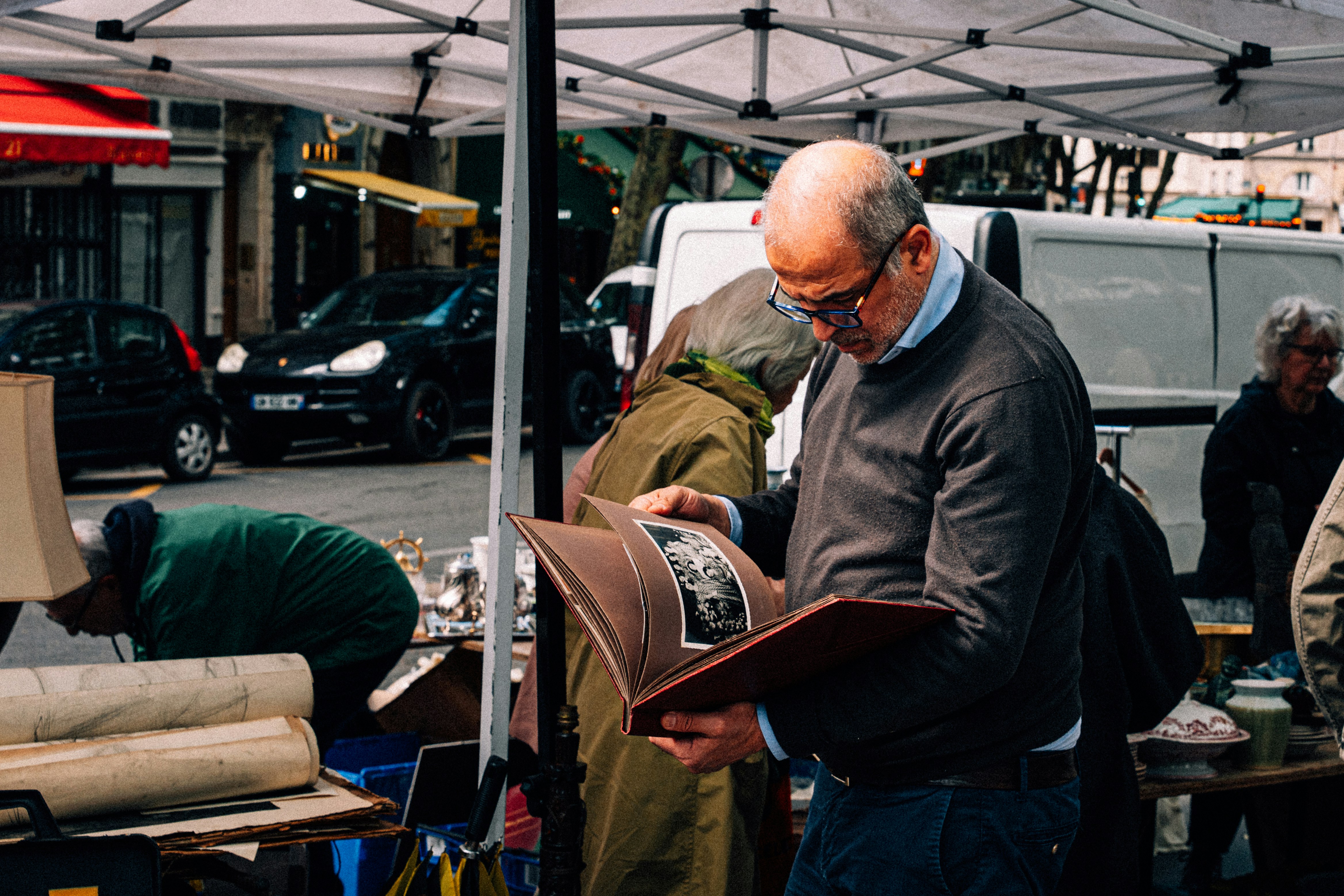 Old Reader Under a Market Canopy