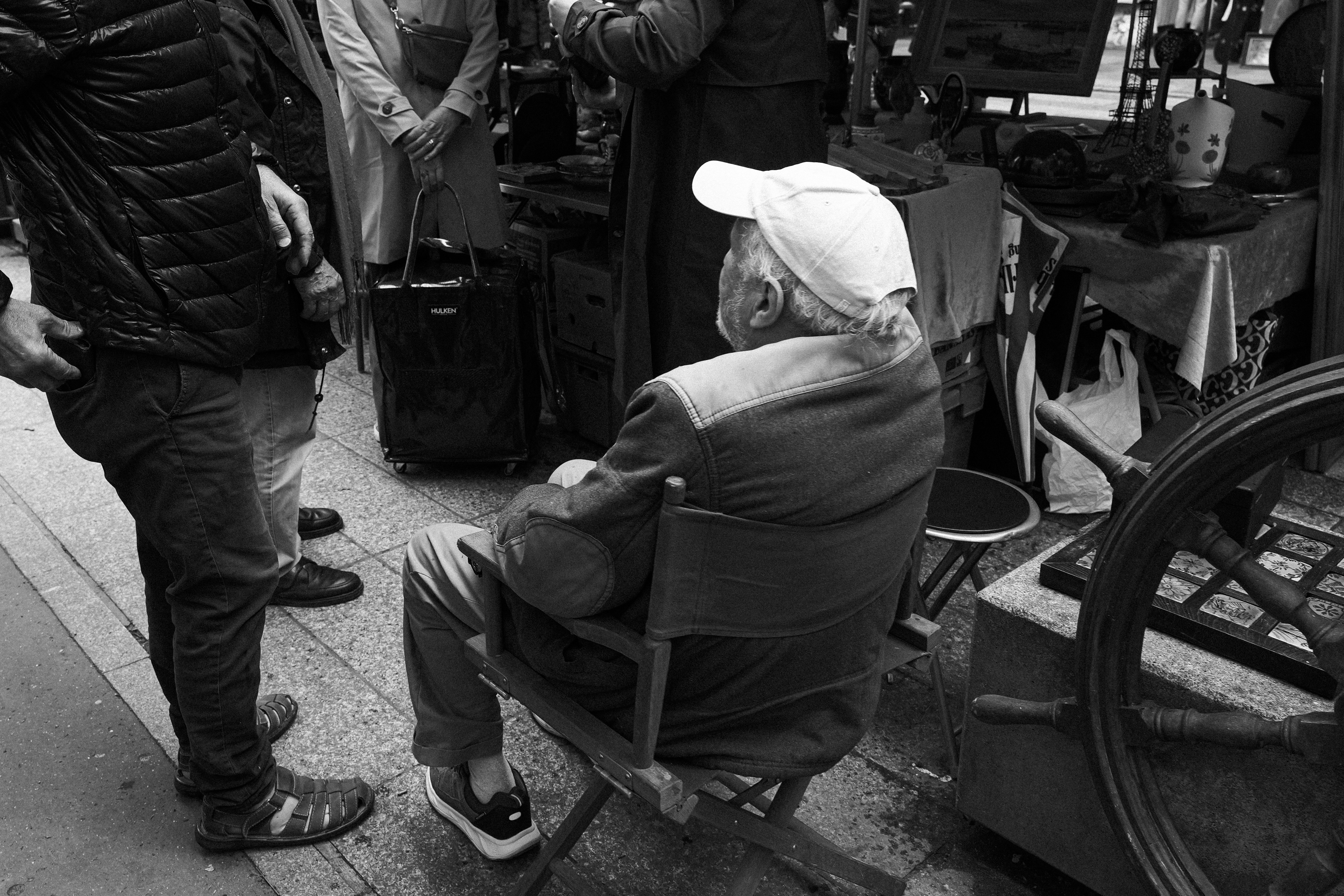 The Streetcar Audience: An Elderly Man in a Cap Tells the Market Scene