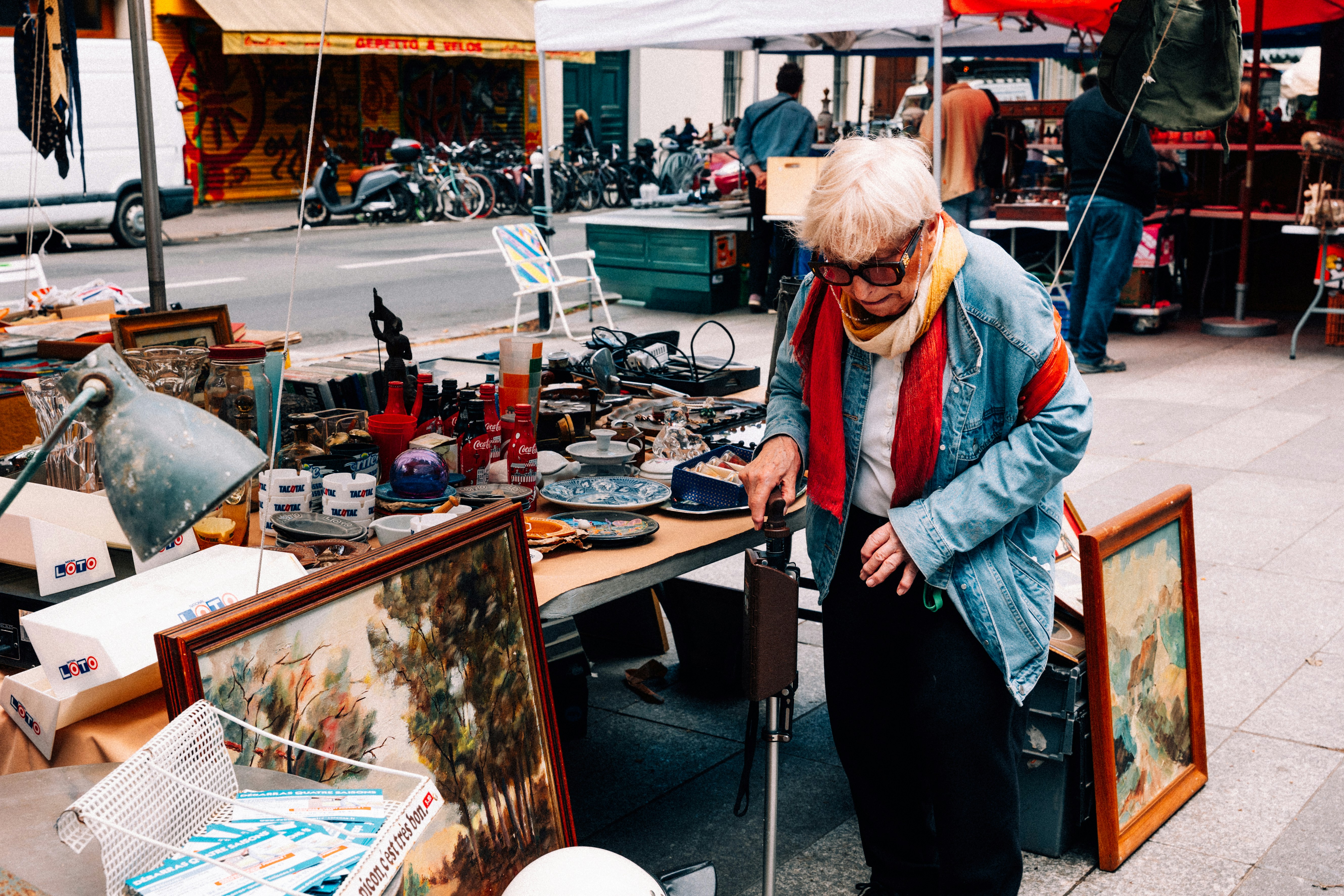 Vintage Market Portrait: The Elderly Vendor at a Busy Street-side Stall