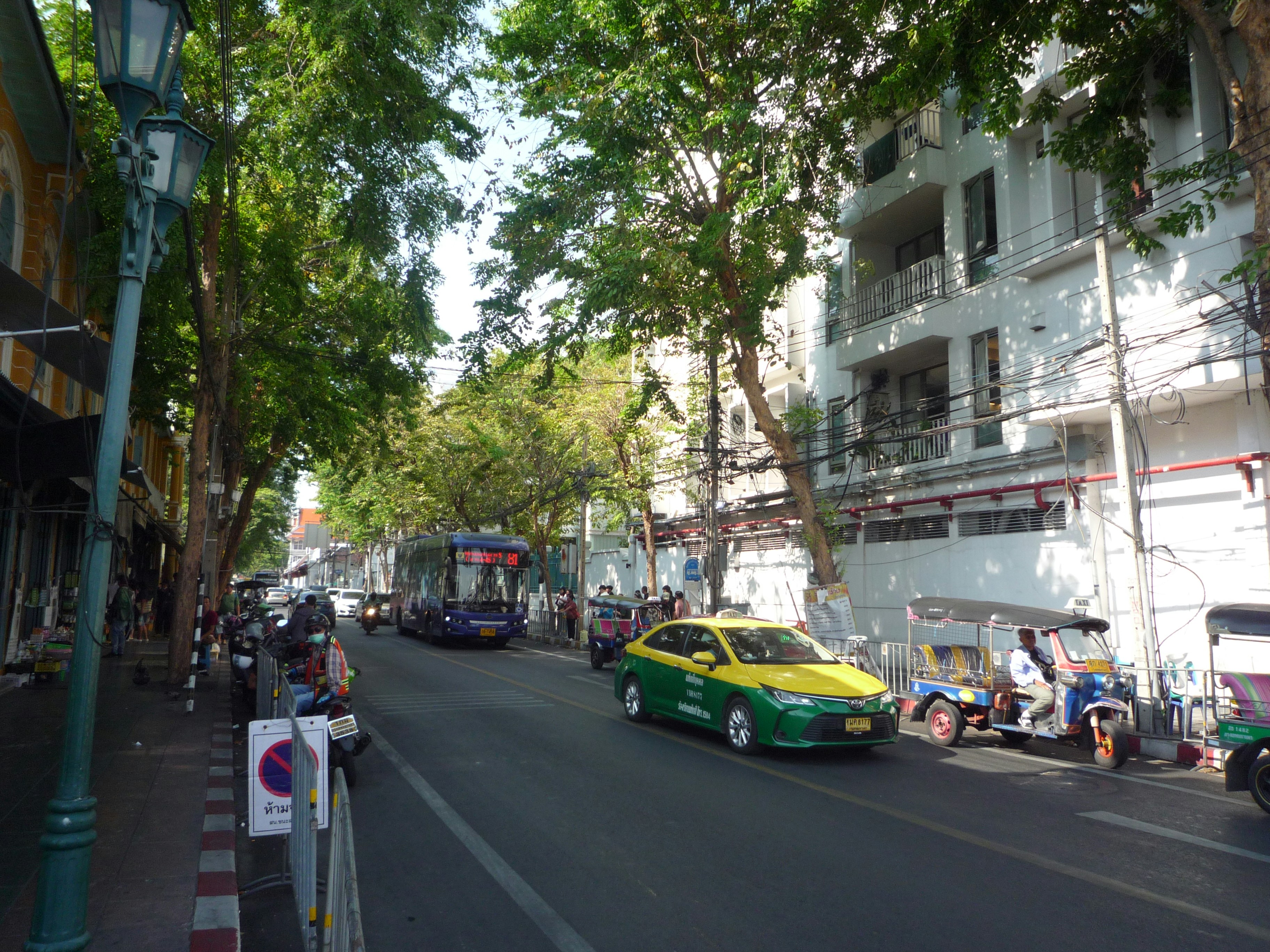 City Street in Motion: Green Taxi Amid Traffic and Shadows