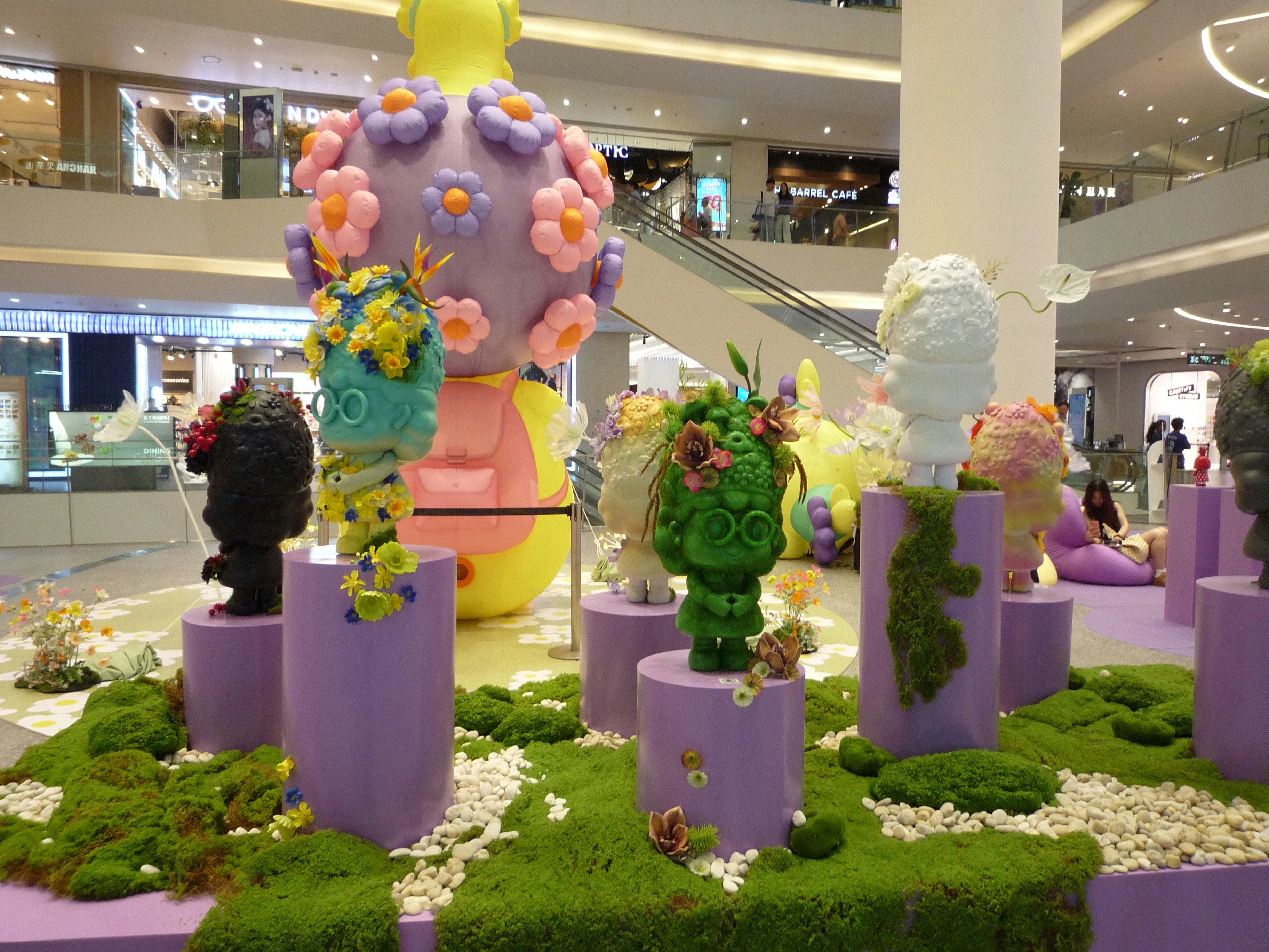 Whimsical Flower Parade: Colorful Sculptures Rise from Purple Platforms