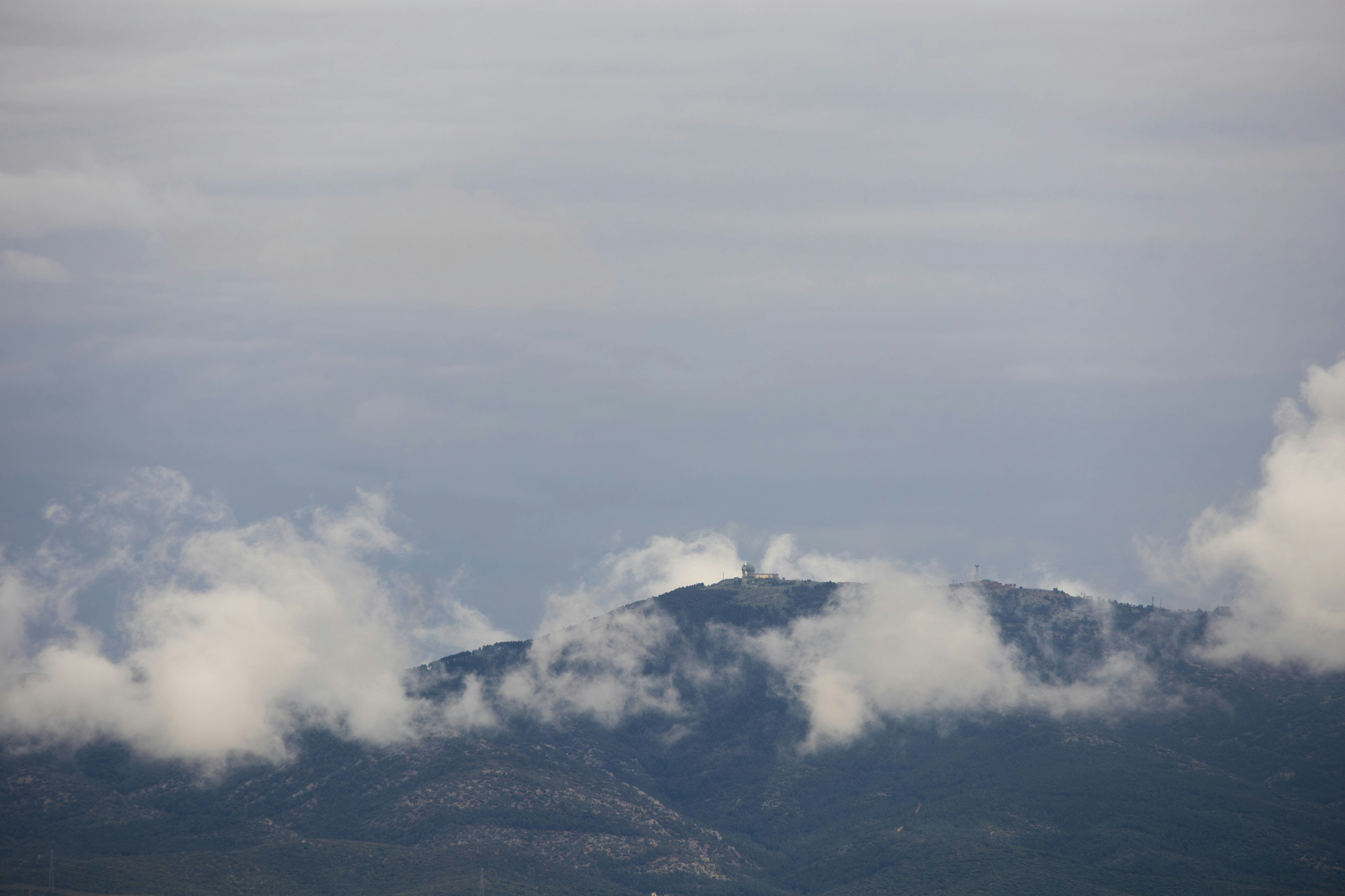 Mist-Shrouded Ridge Beneath a Quiet Sky