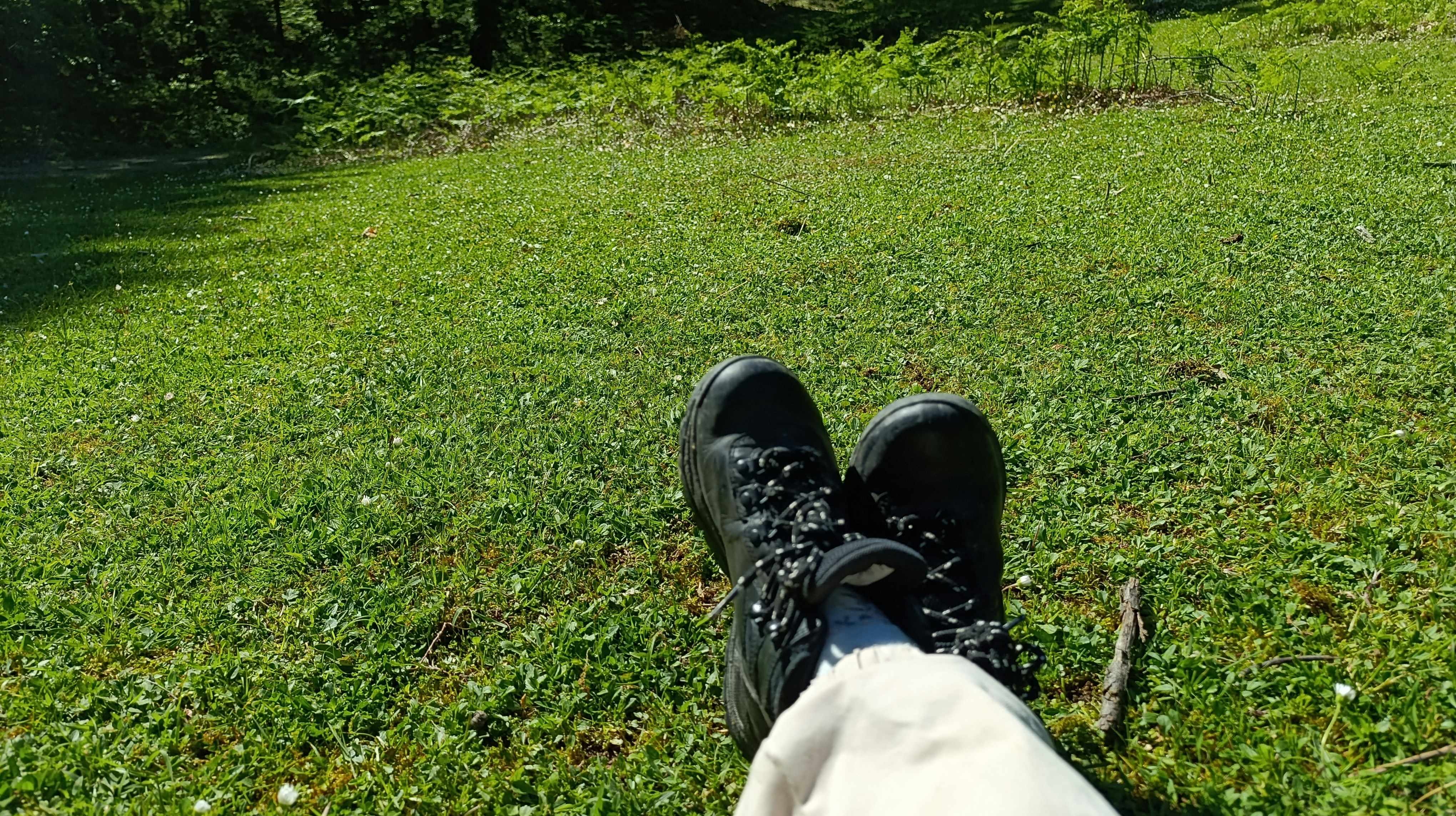 A person's feet in hiking boots resting on grass