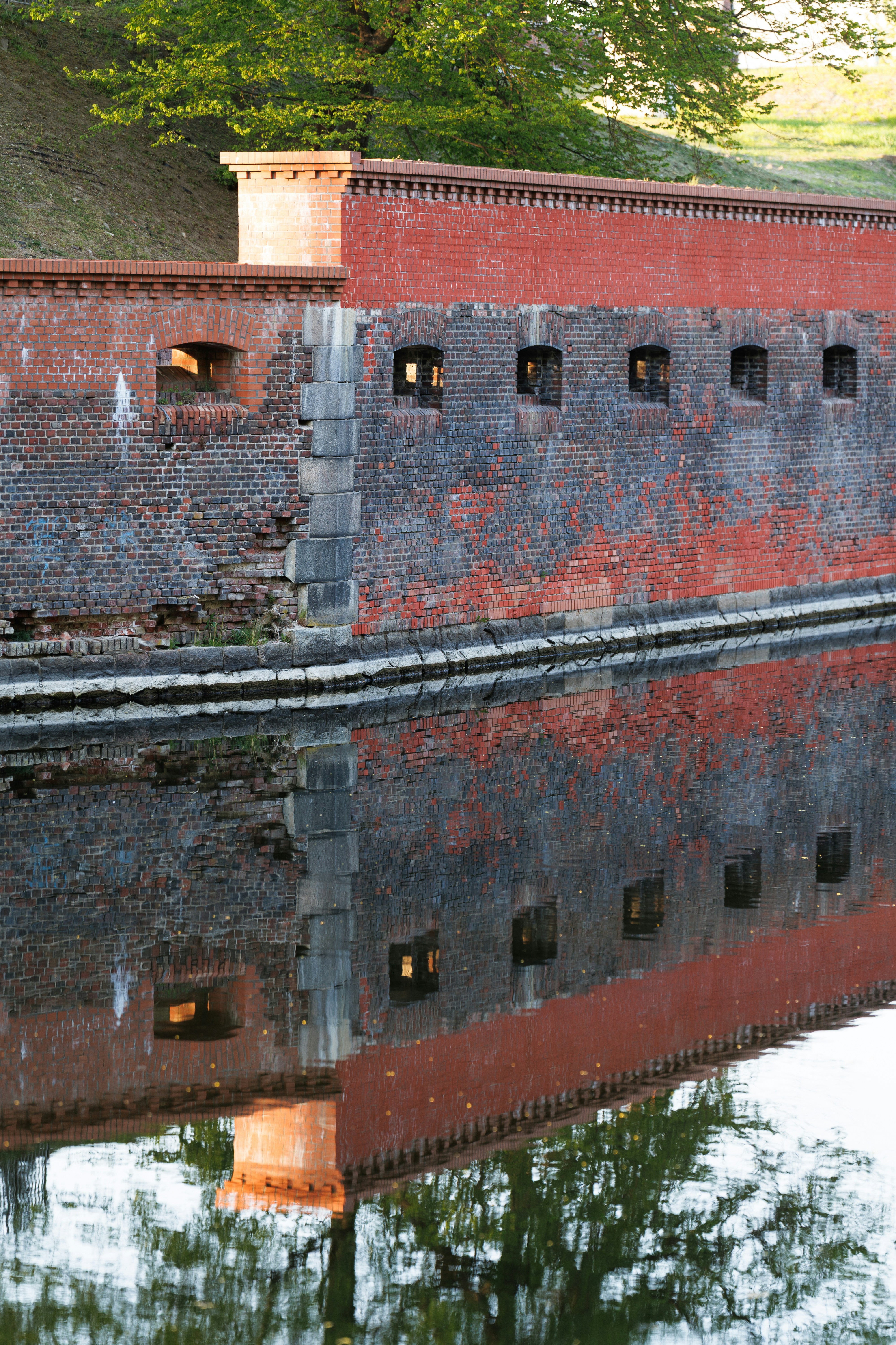 Reflected Red Brick Wall by Water’s Edge