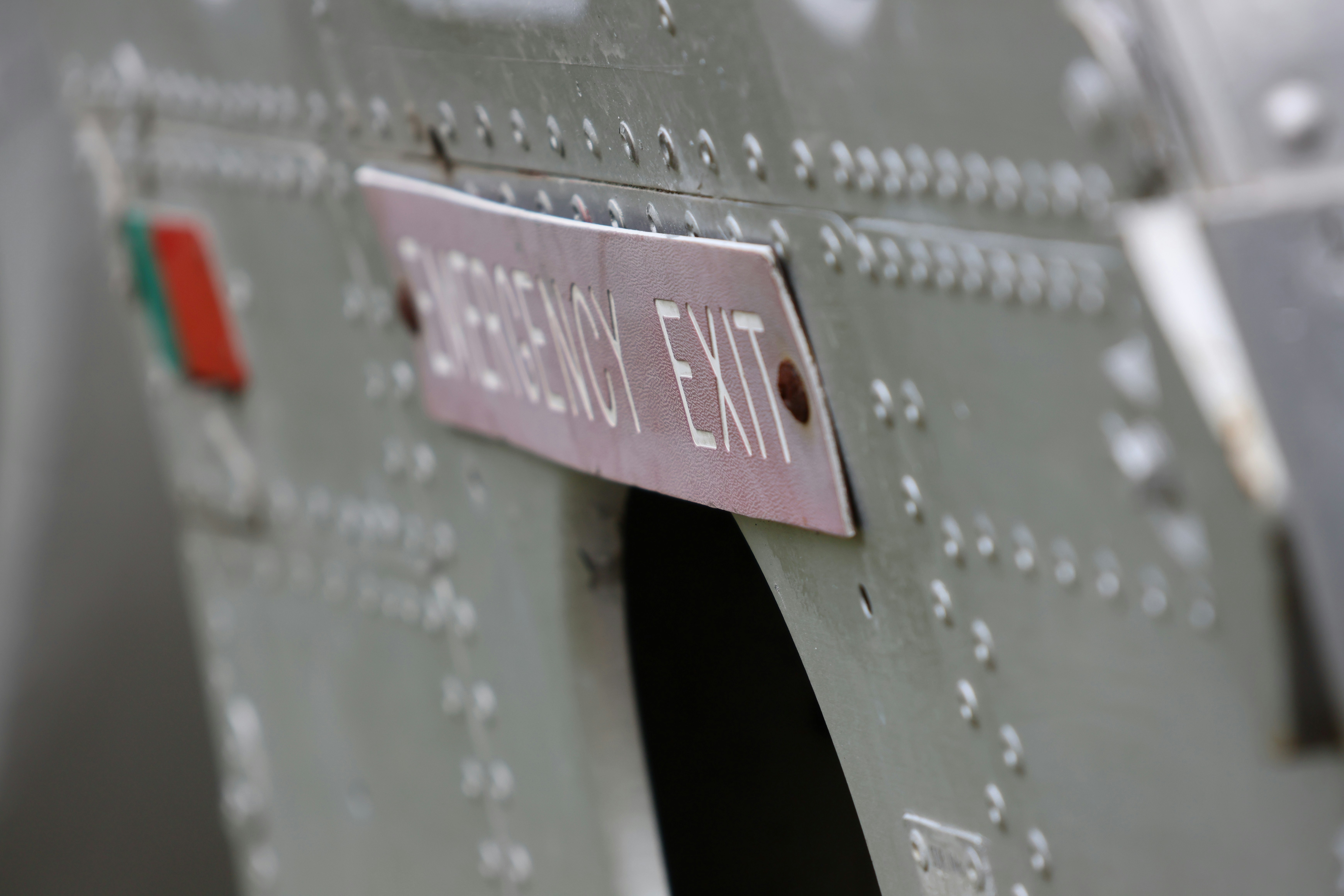 Close-up of a weathered emergency exit hatch on a military aircraft