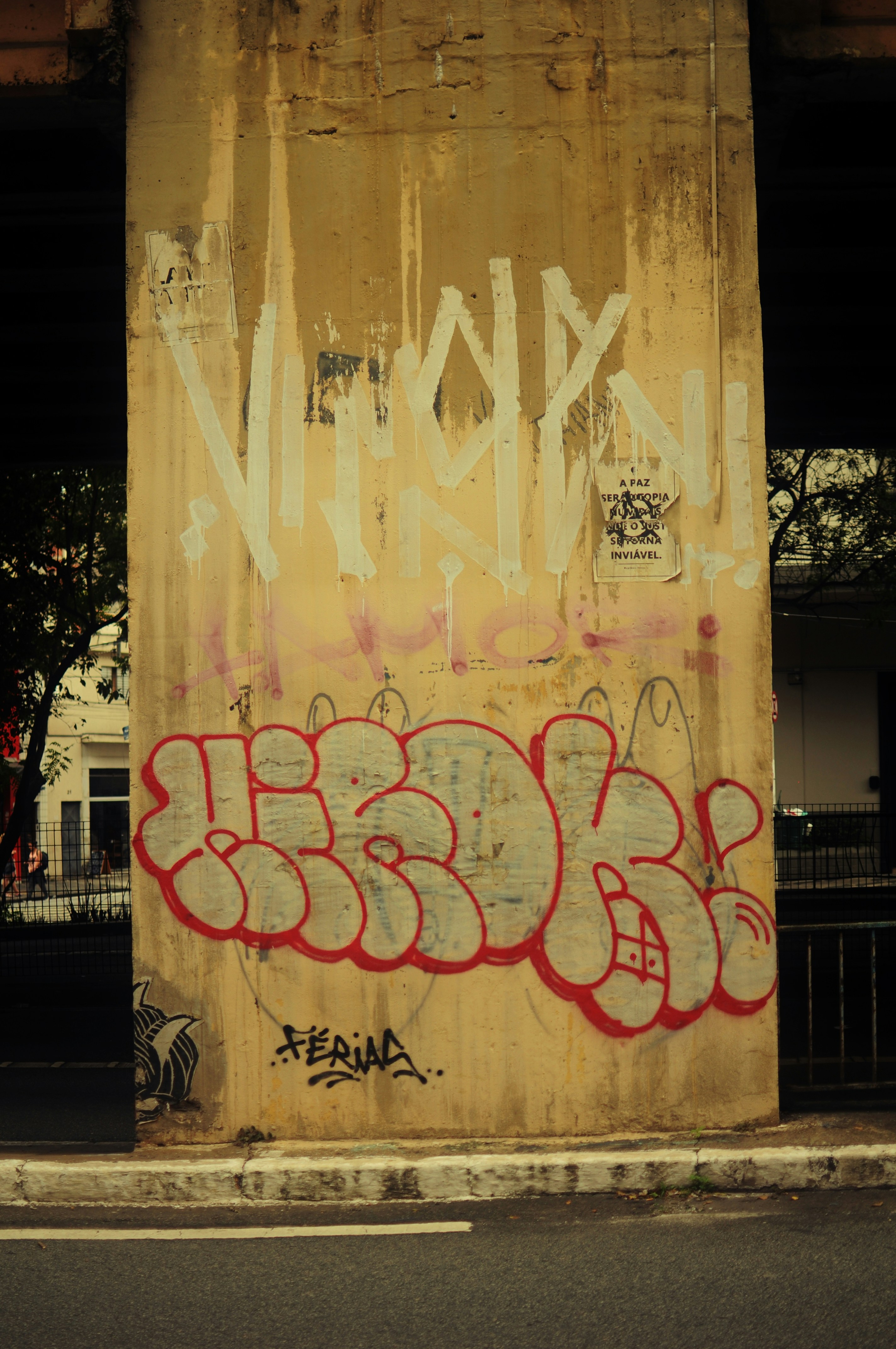 Graffiti Pillar: Red Tag Amid Weathered Concrete Underpass