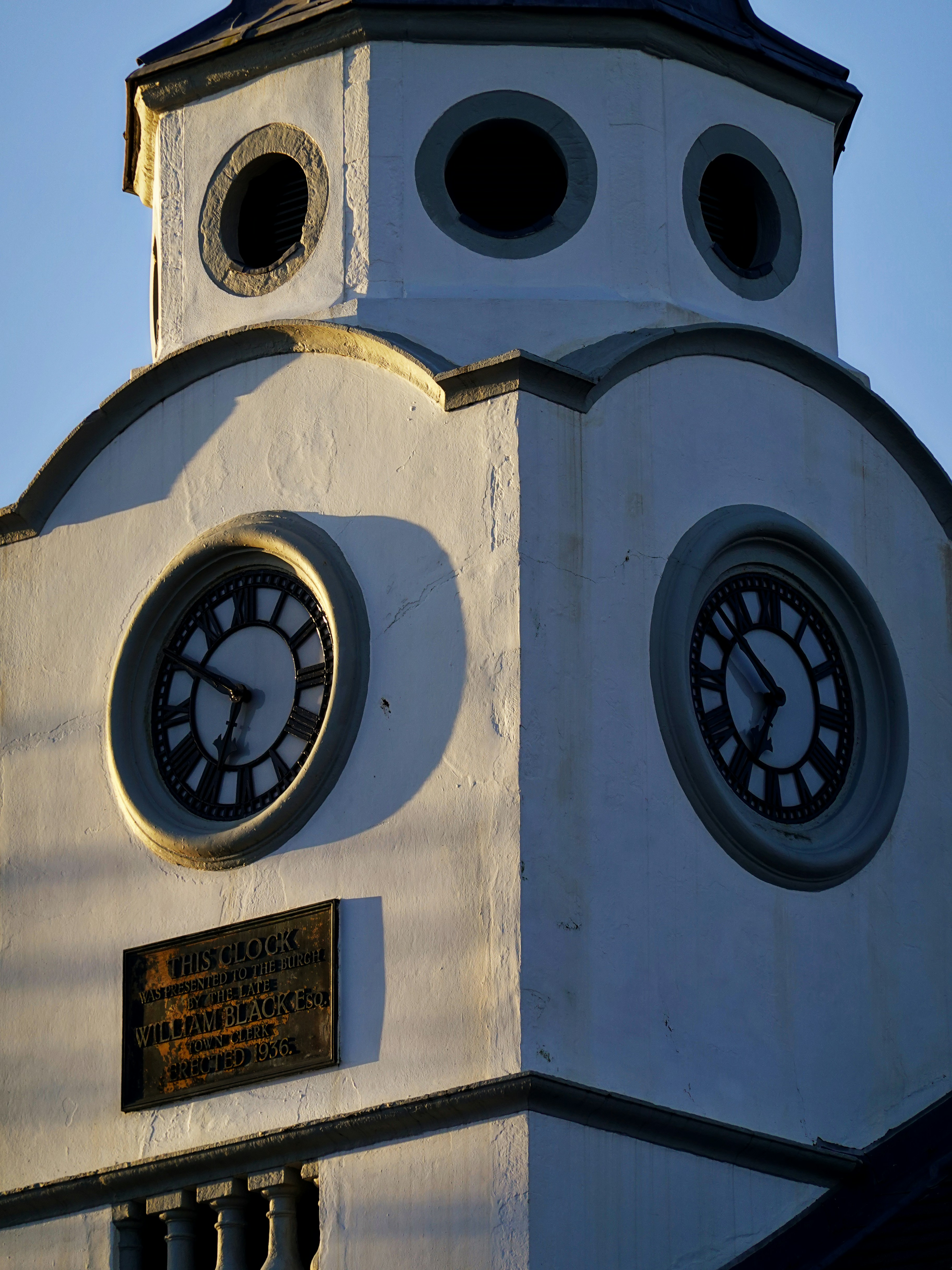 Clocktower Corner: Sunlit White Facade and Circular Dials