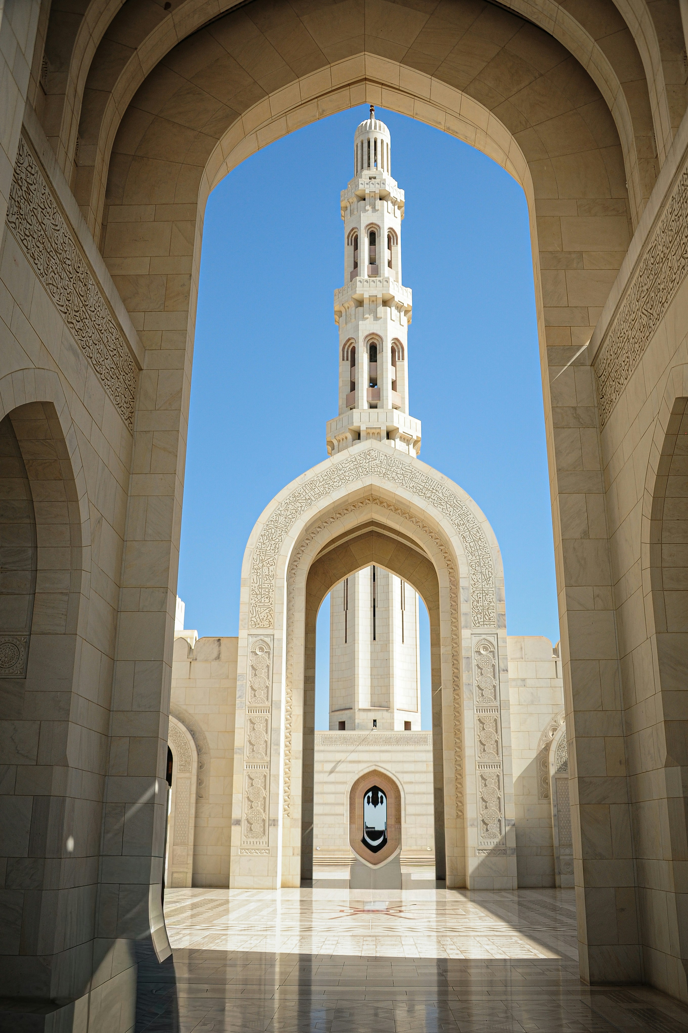Archway to the Tower: A Symmetrical Cathedral Path Under Blue Sky