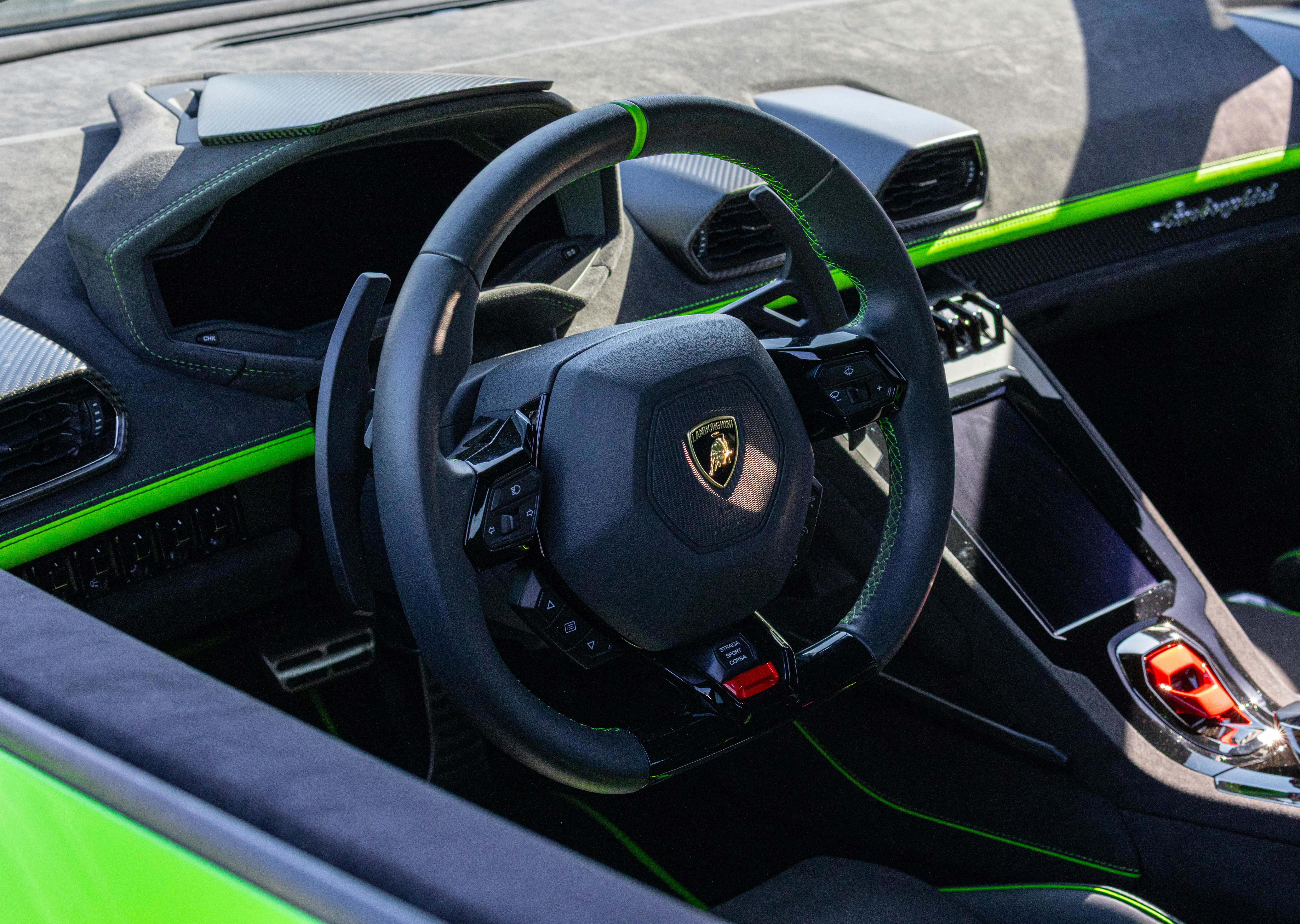 Green supercar cockpit: steering wheel at the center of a neon-lined interior
