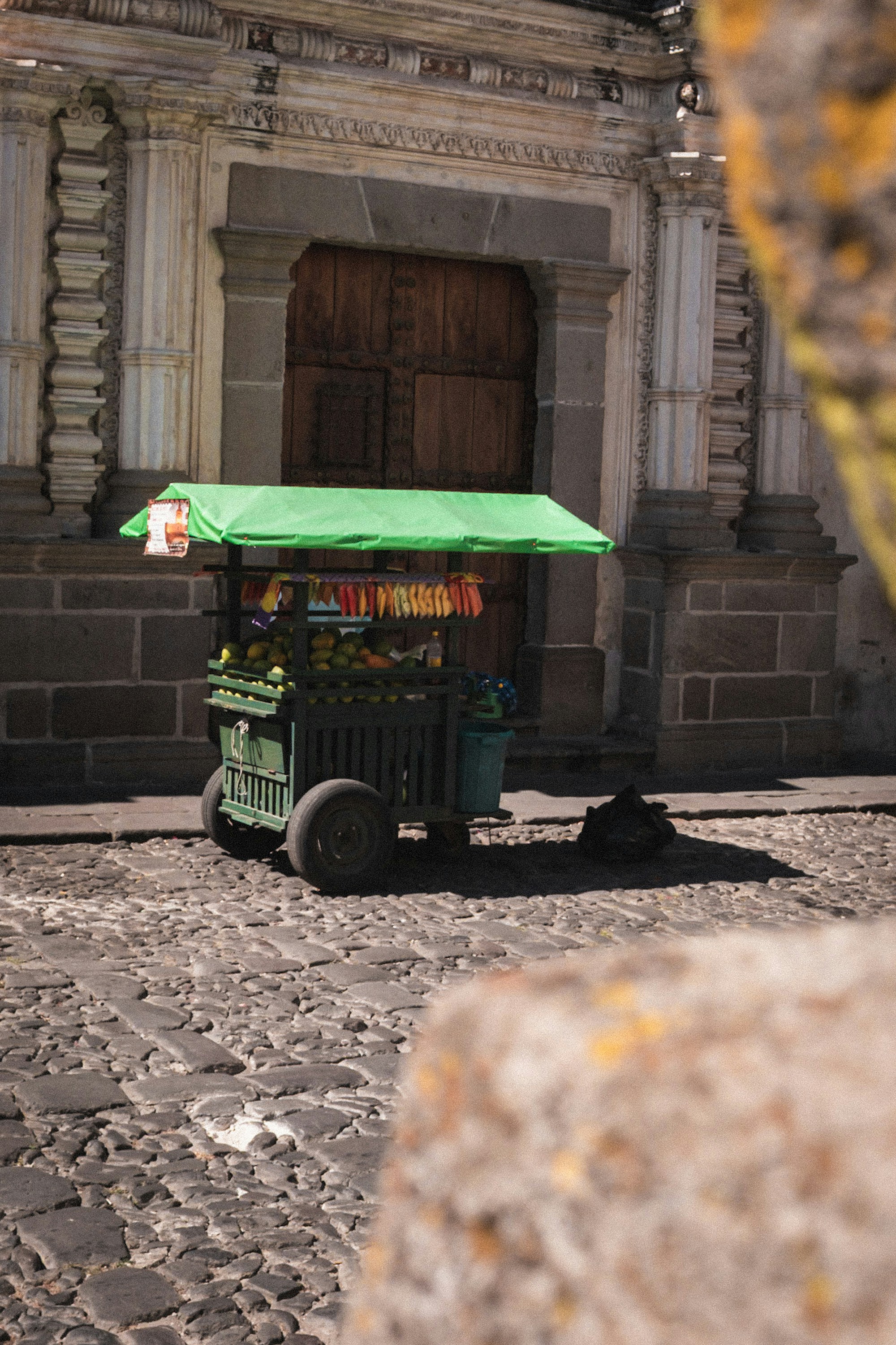 Green Cart in the Shadow of a Historic Portal
