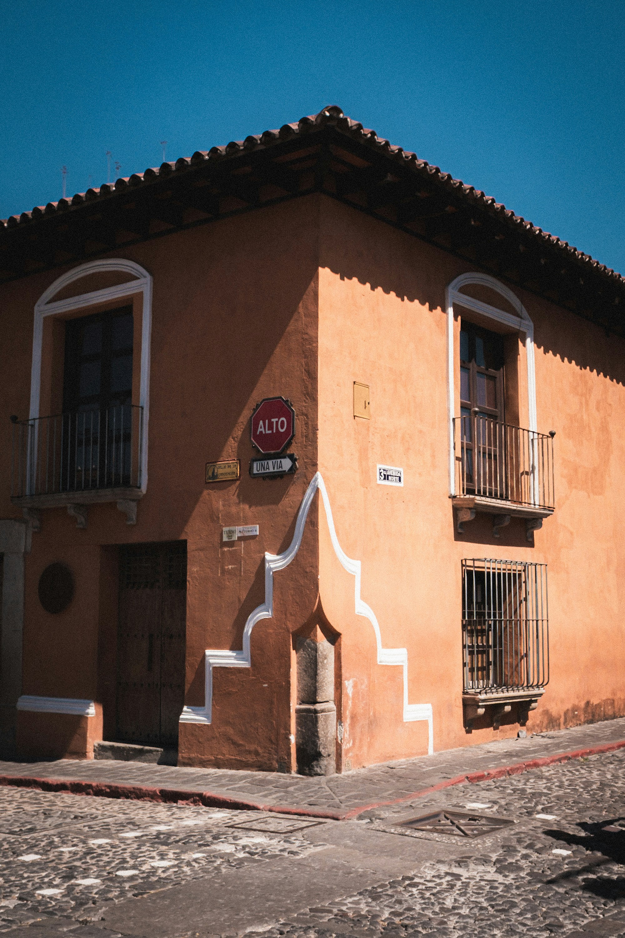 Terracotta Corner: A Sunlit Spanish Facade with White Moorish Accents