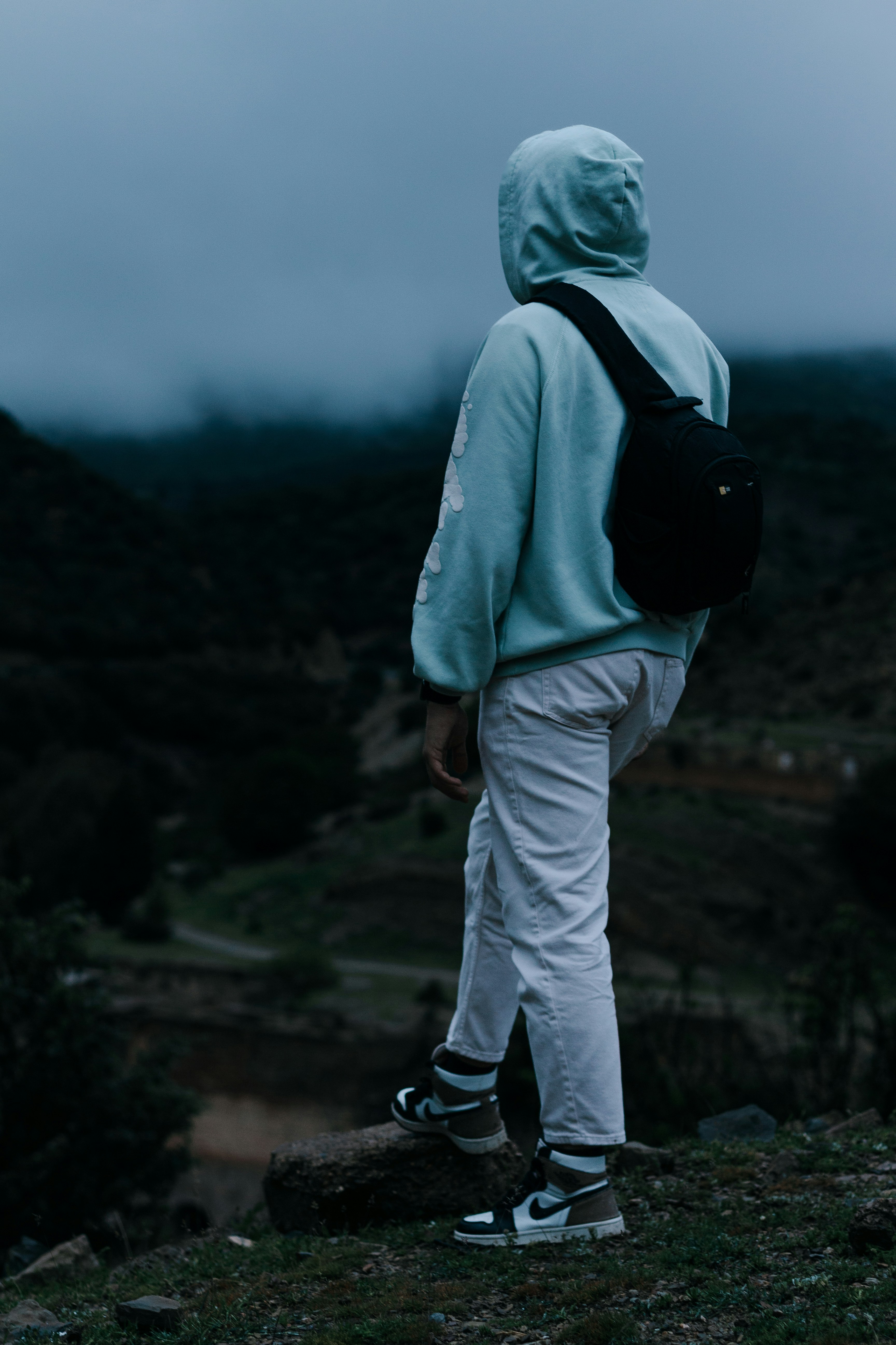 A Quiet Ascent: Backpacker Standing on a Cliff Edge