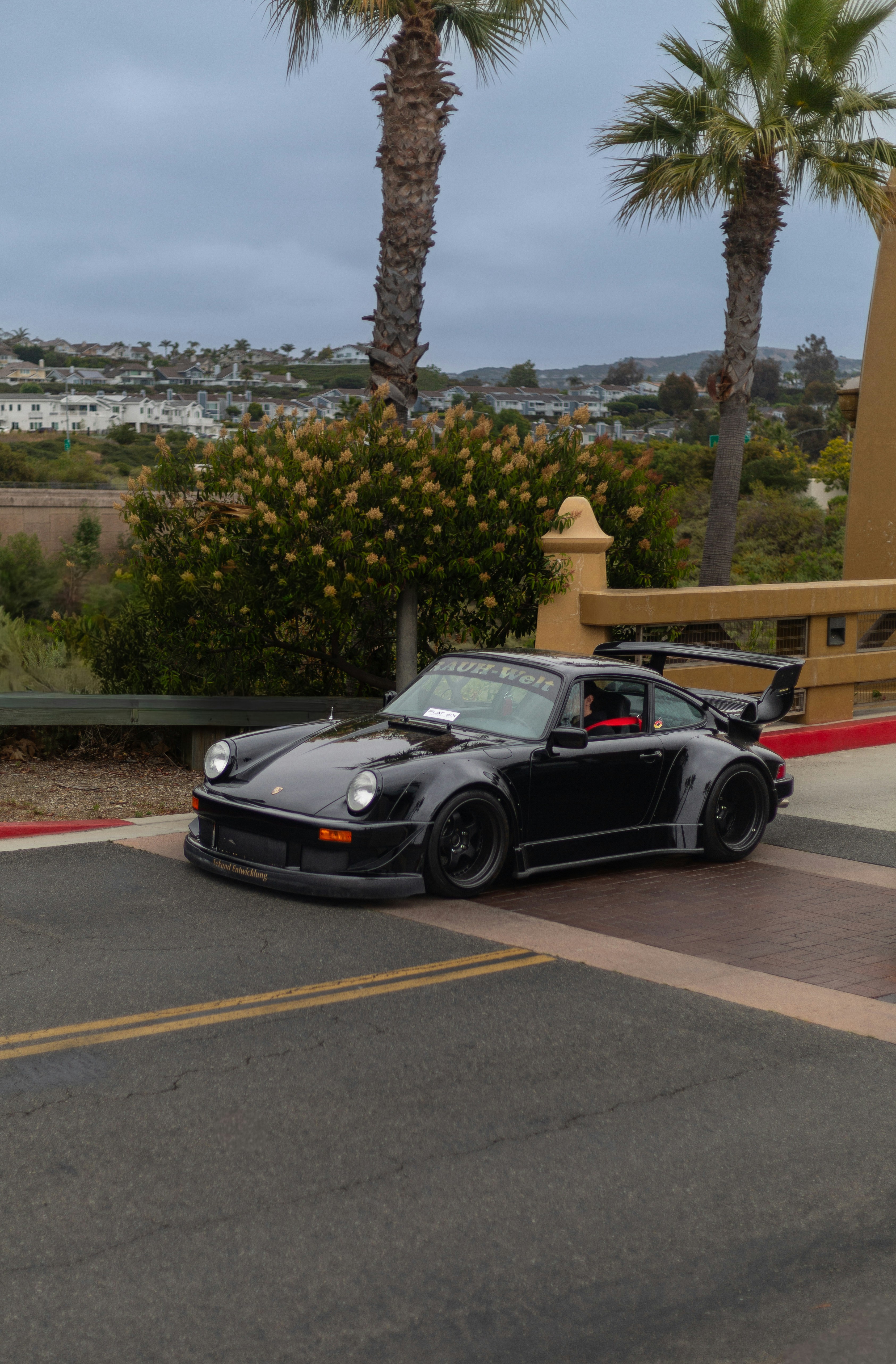 Black Porsche Stance: Sunset Drive Past Coastal Villas