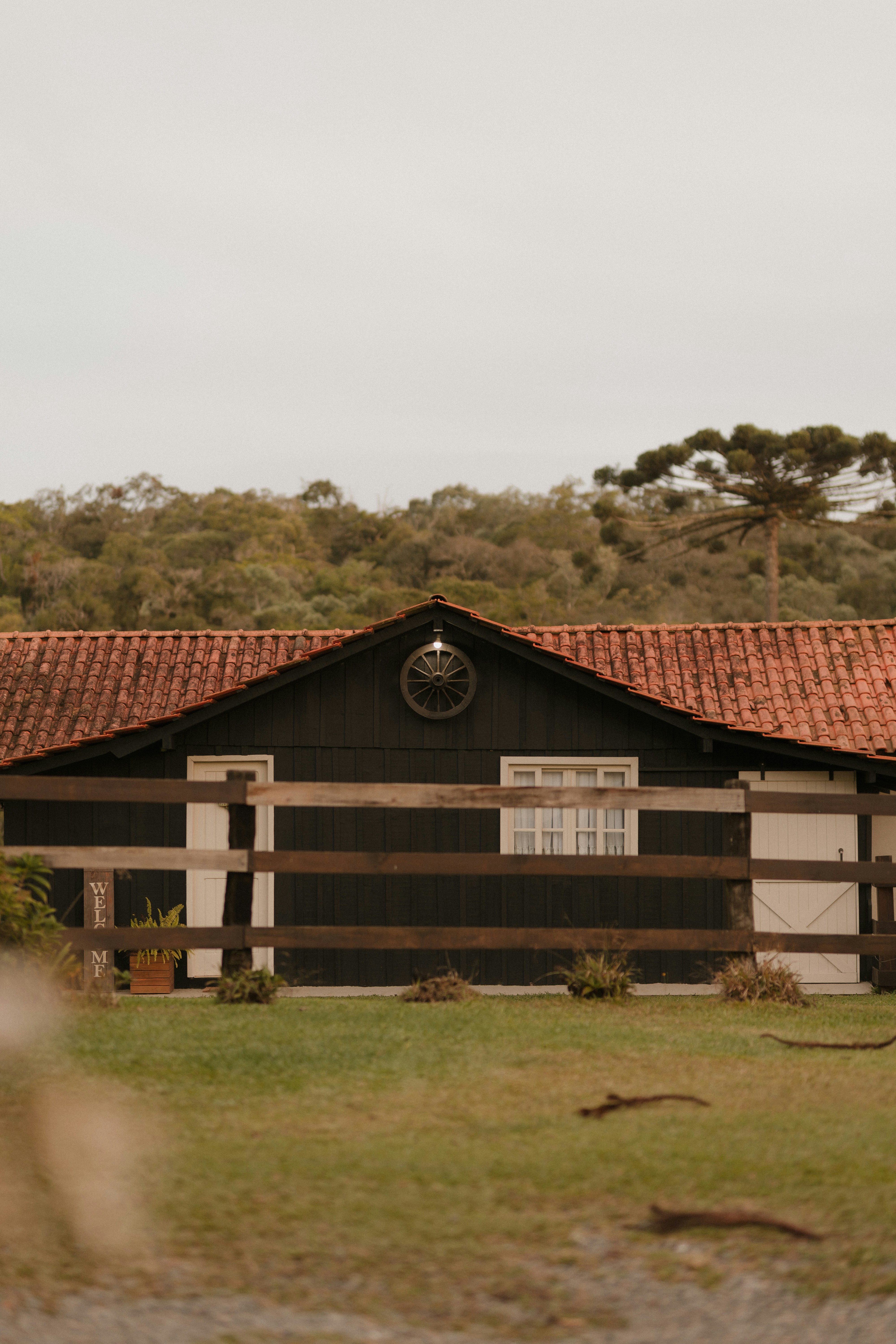 Barn with Wagon Wheel Crest Under a Rust-Red Roof