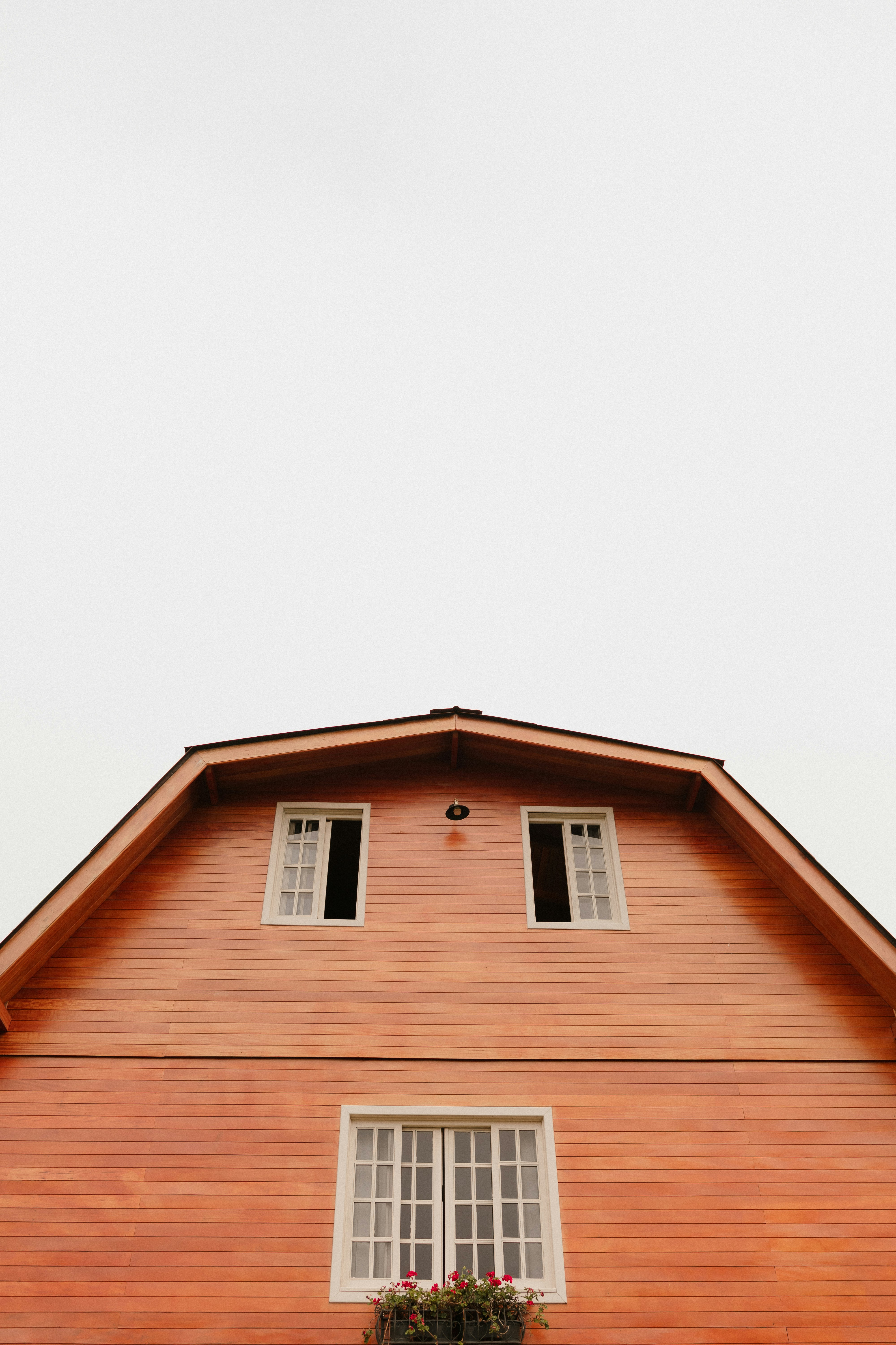 Orange House Under a Pale Sky: A Symmetrical Gable in Focus