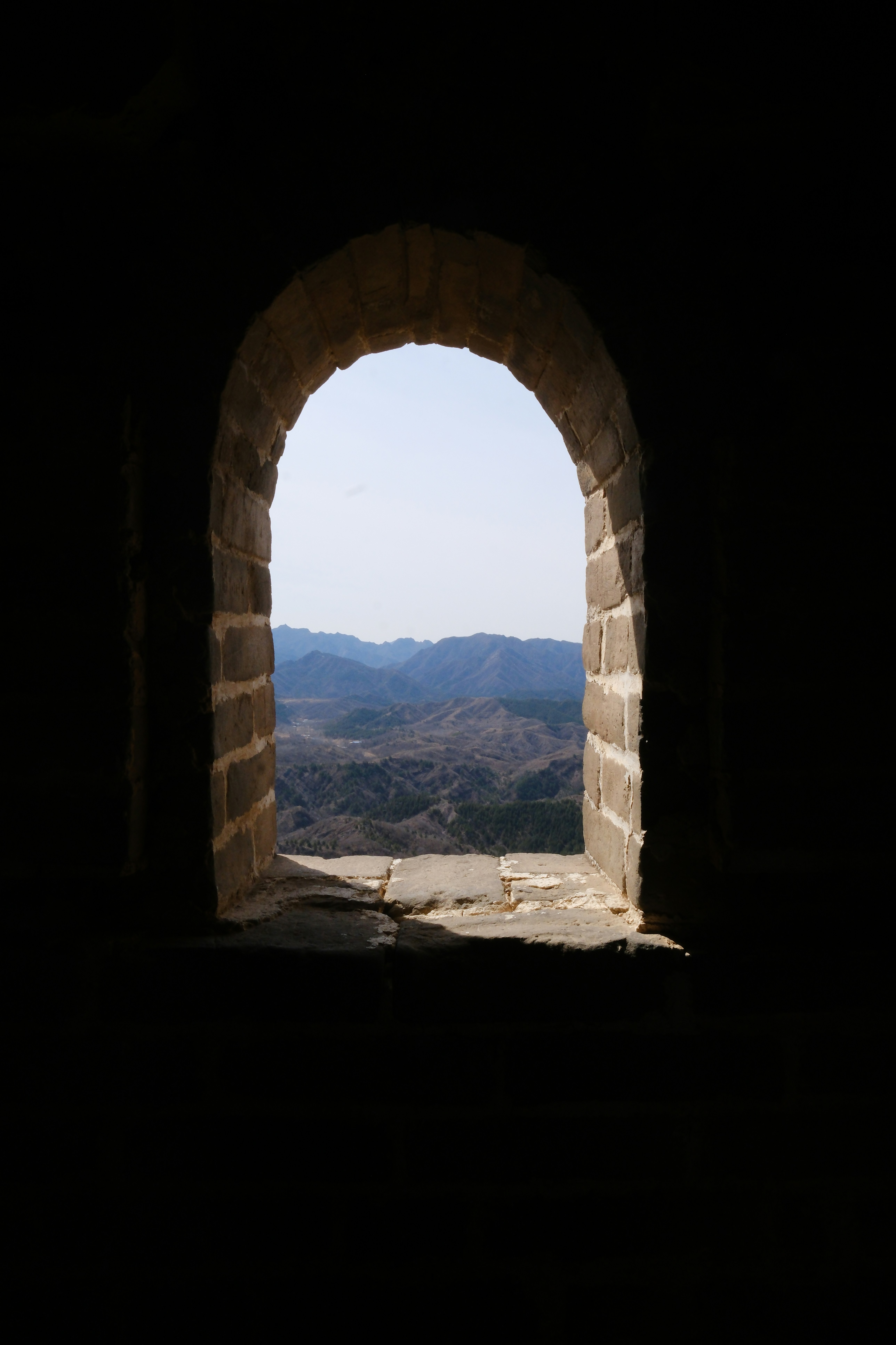 View Through a Stone Archway into Distant Mountains