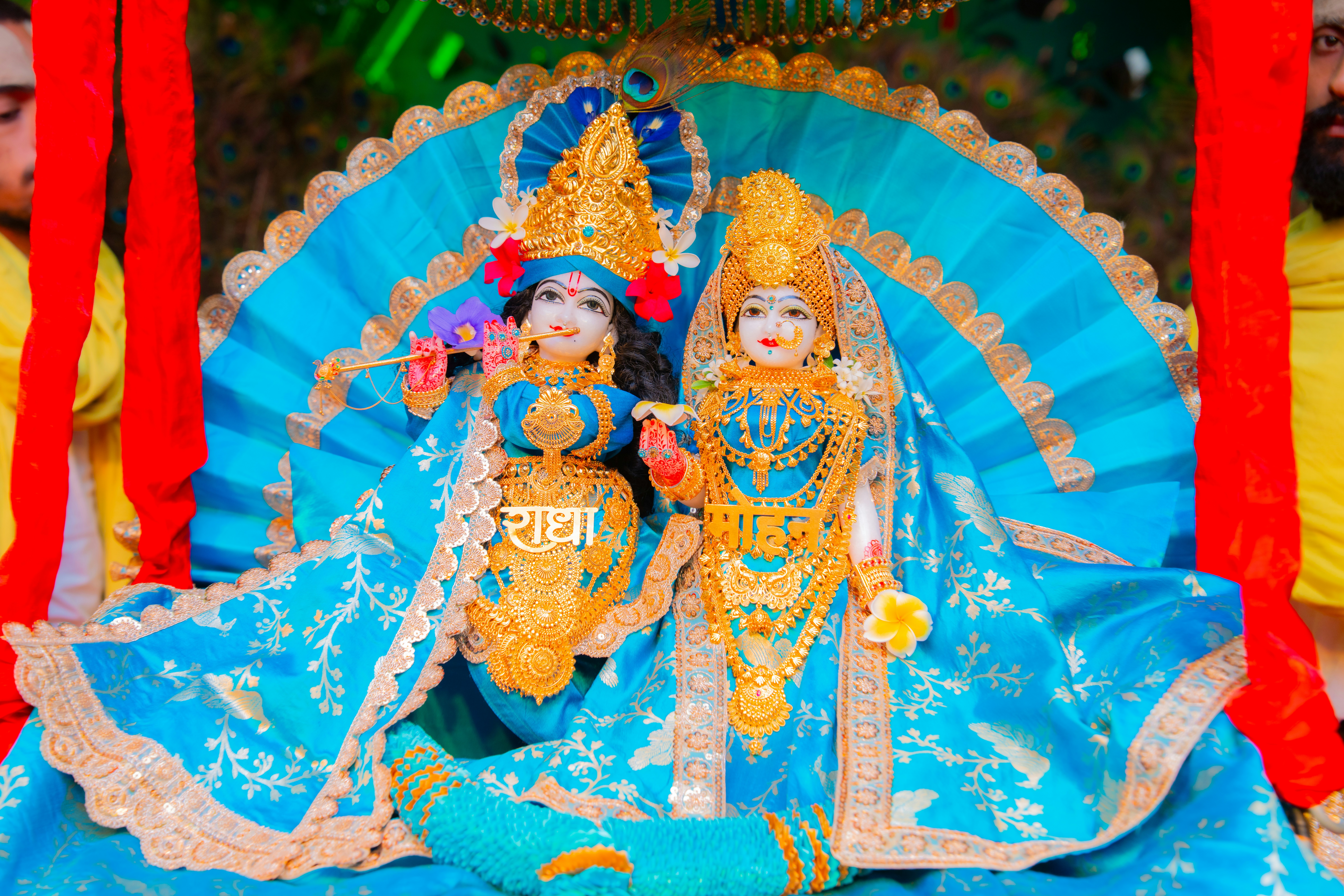 Radiant Dolls in Ceremonial Attire under a Peacock Blues