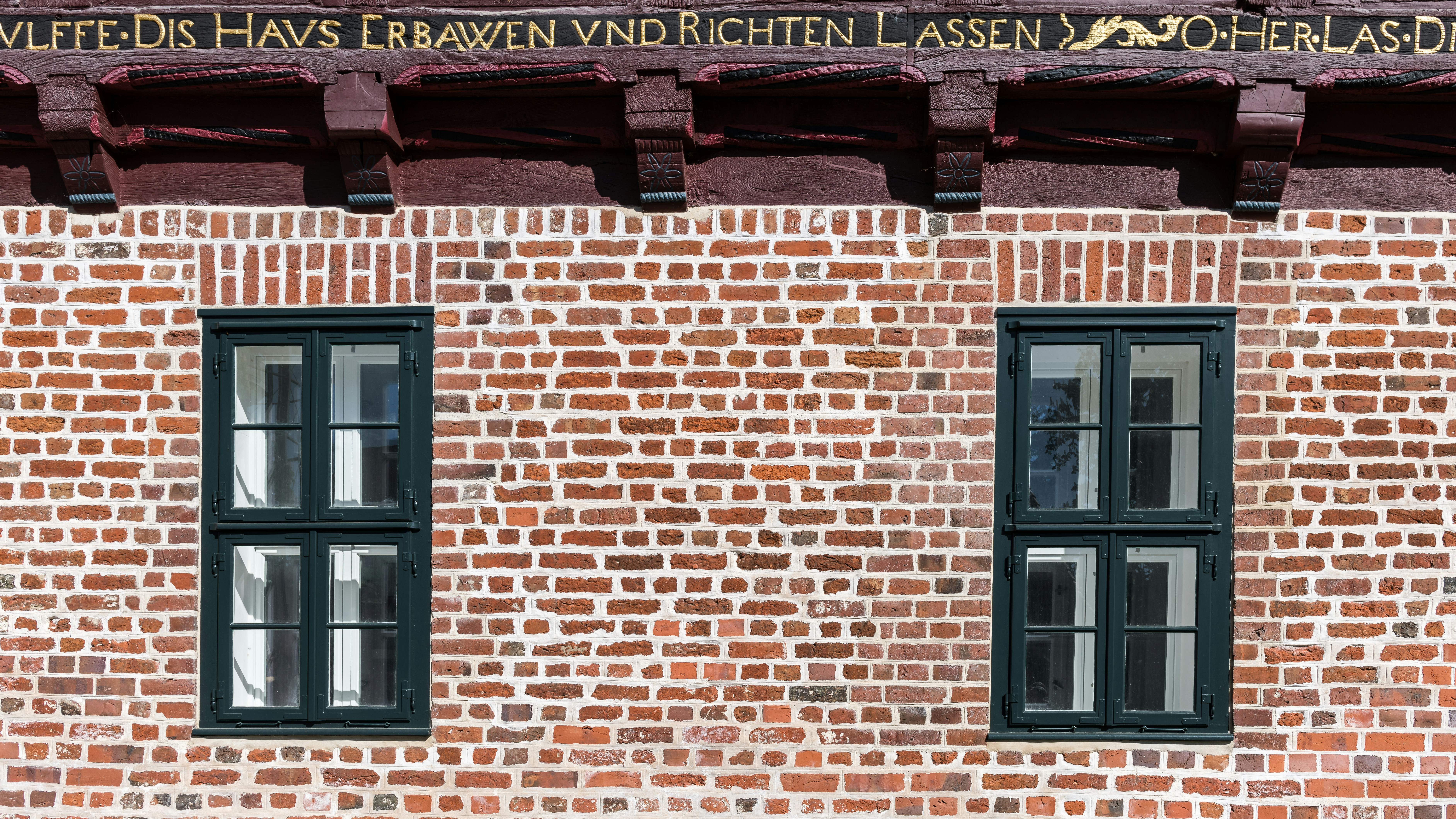 Brickwork Rhythm: Two Dark Windows in a Dutch Gable