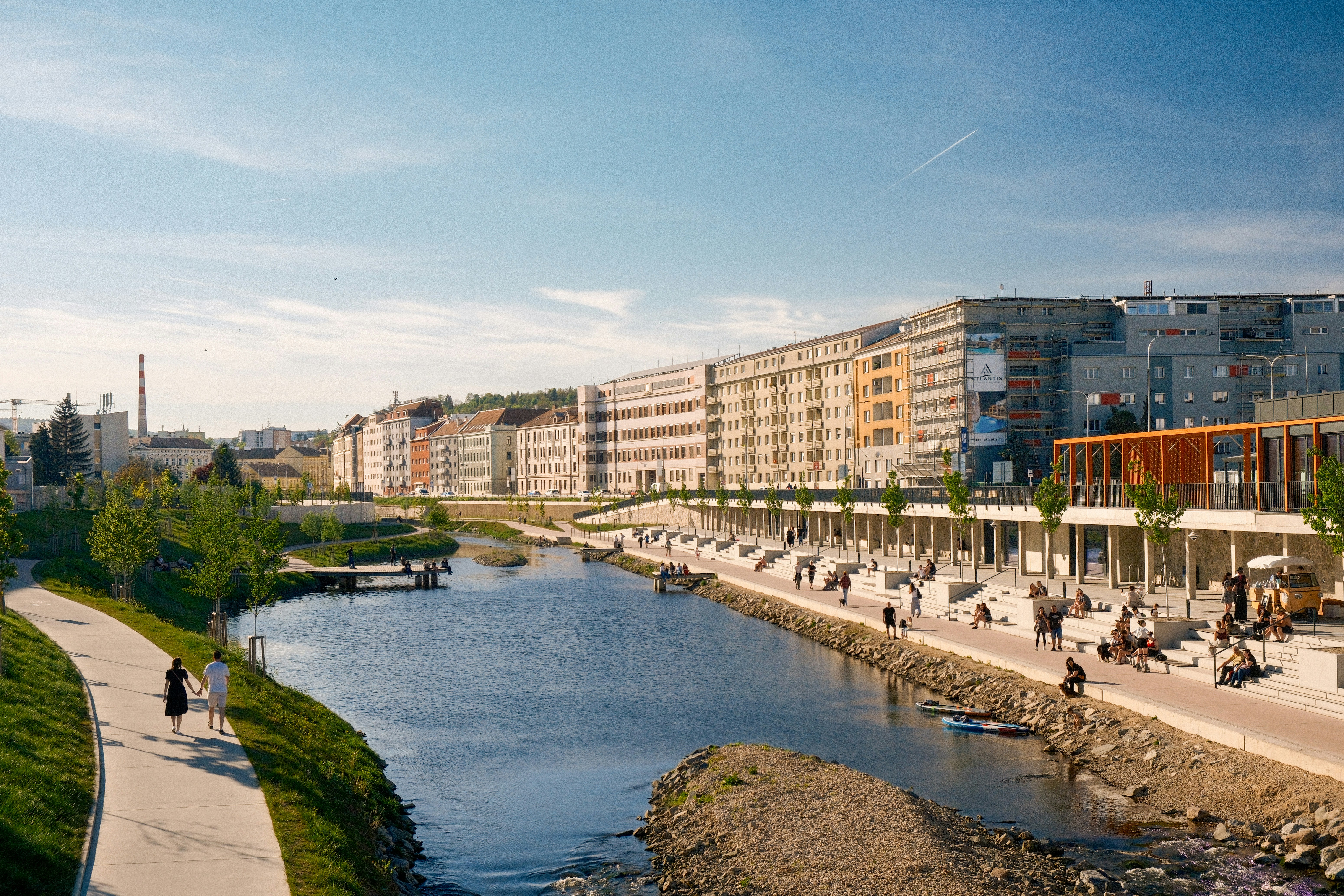 Urban Riverside Arcades: A Sunlit Waterfront promenade along modern apartments