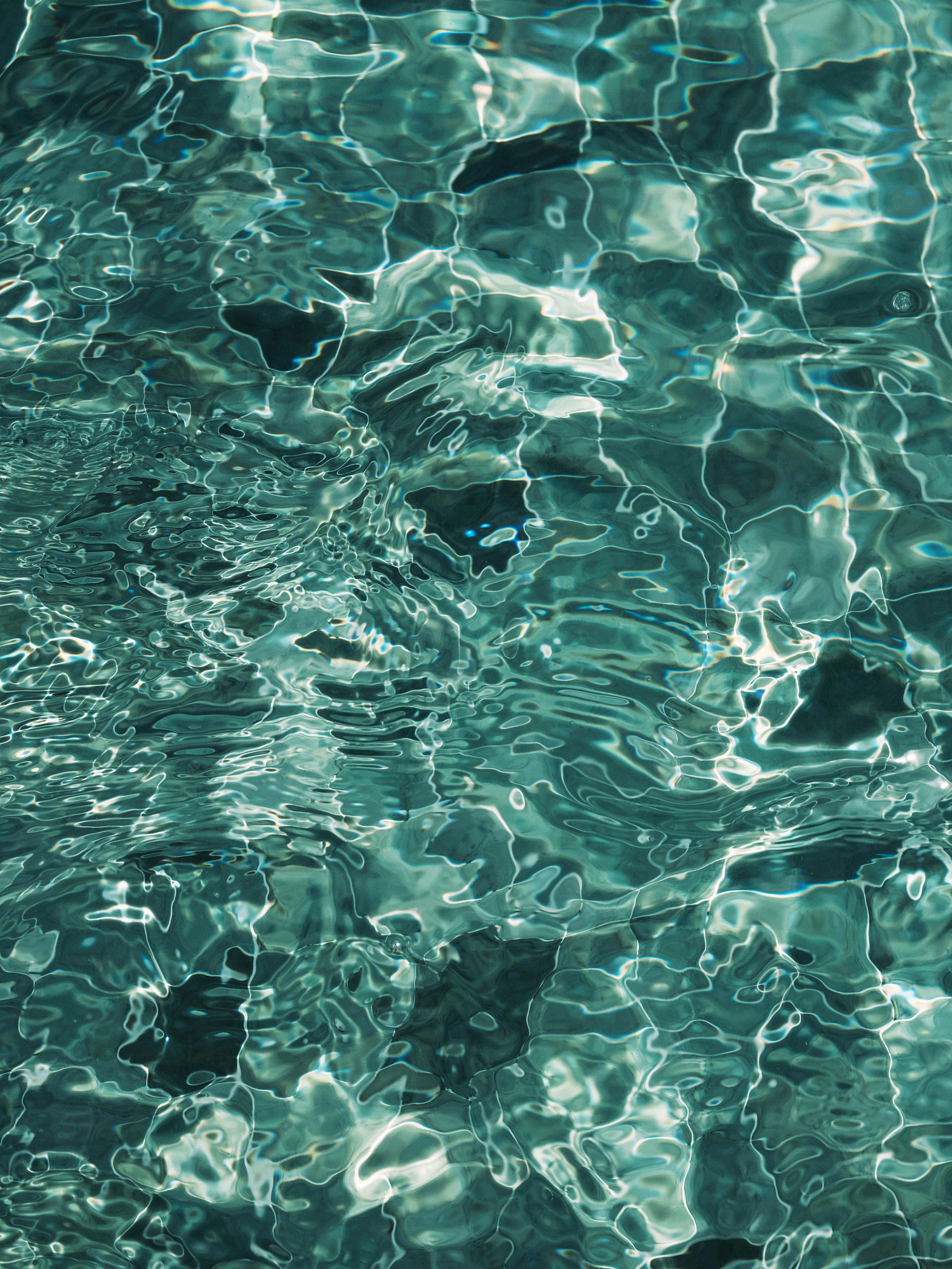 Liquid Mosaic: Sunlit Ripples Across Teal Waters