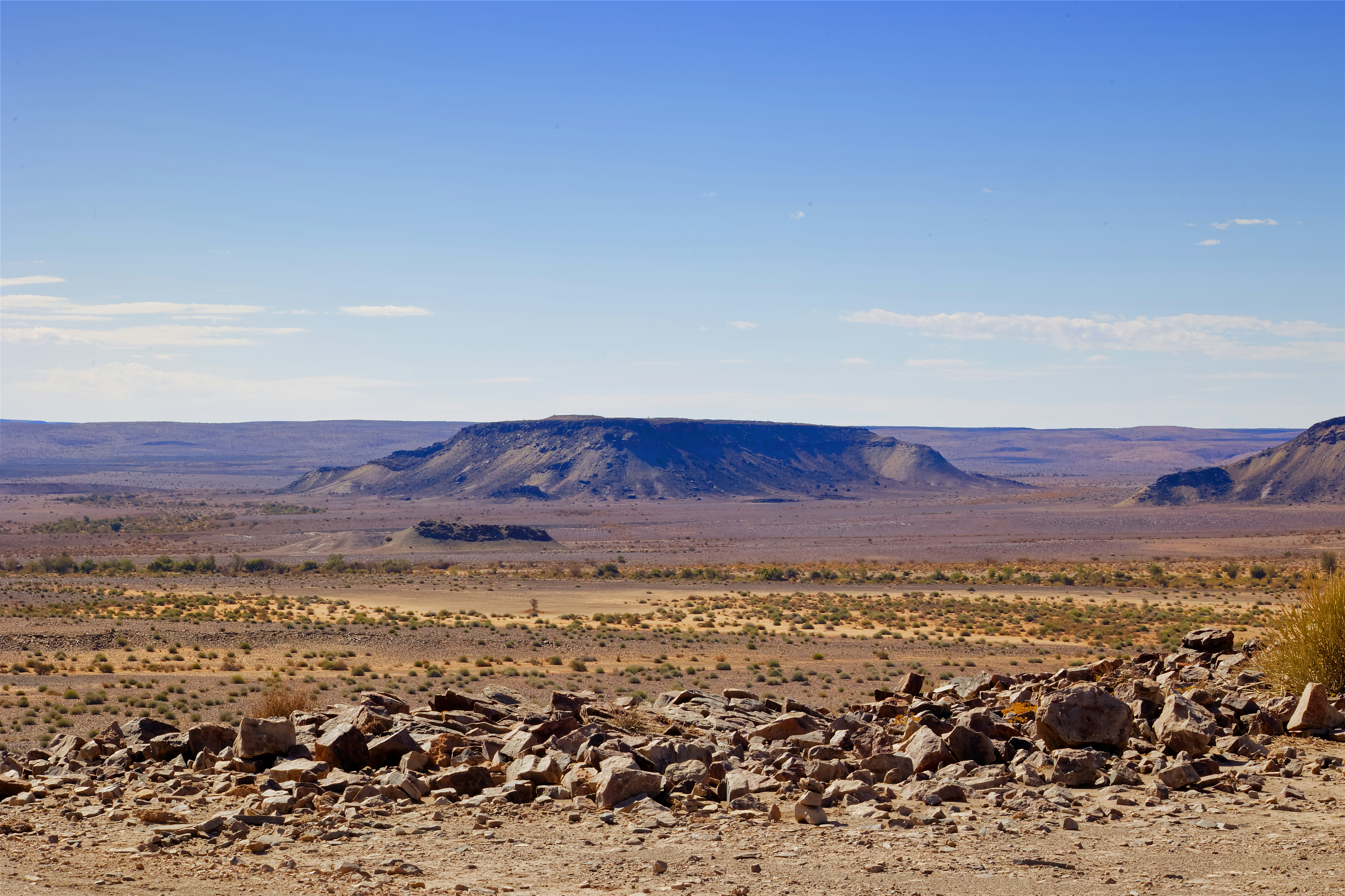 Desert Rim: Silhouetted mesas beneath a pale blue sky