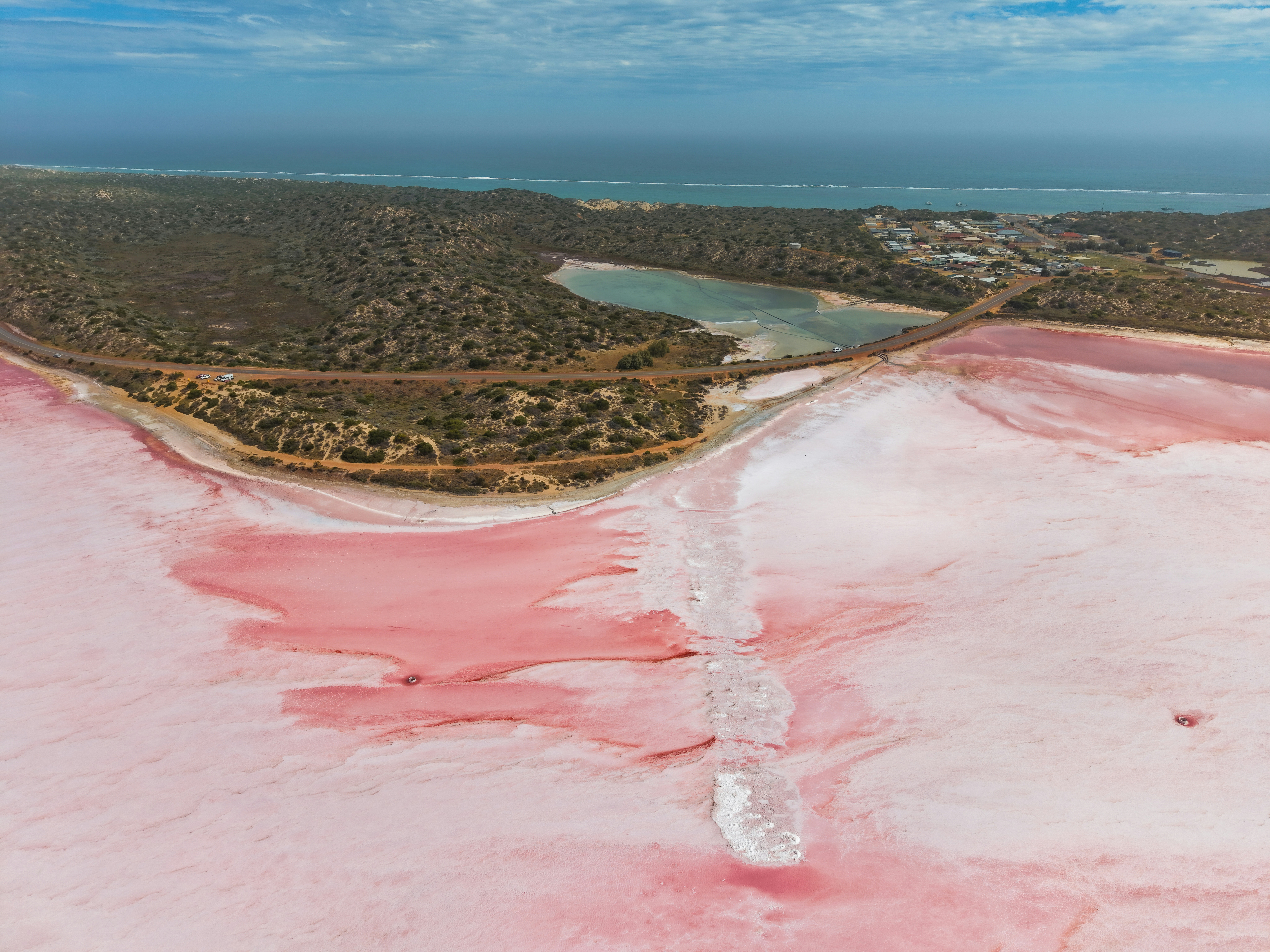 Pink Salt Flats Drain to Turquoise Lagoon: A Coastal Salt Pan Vista