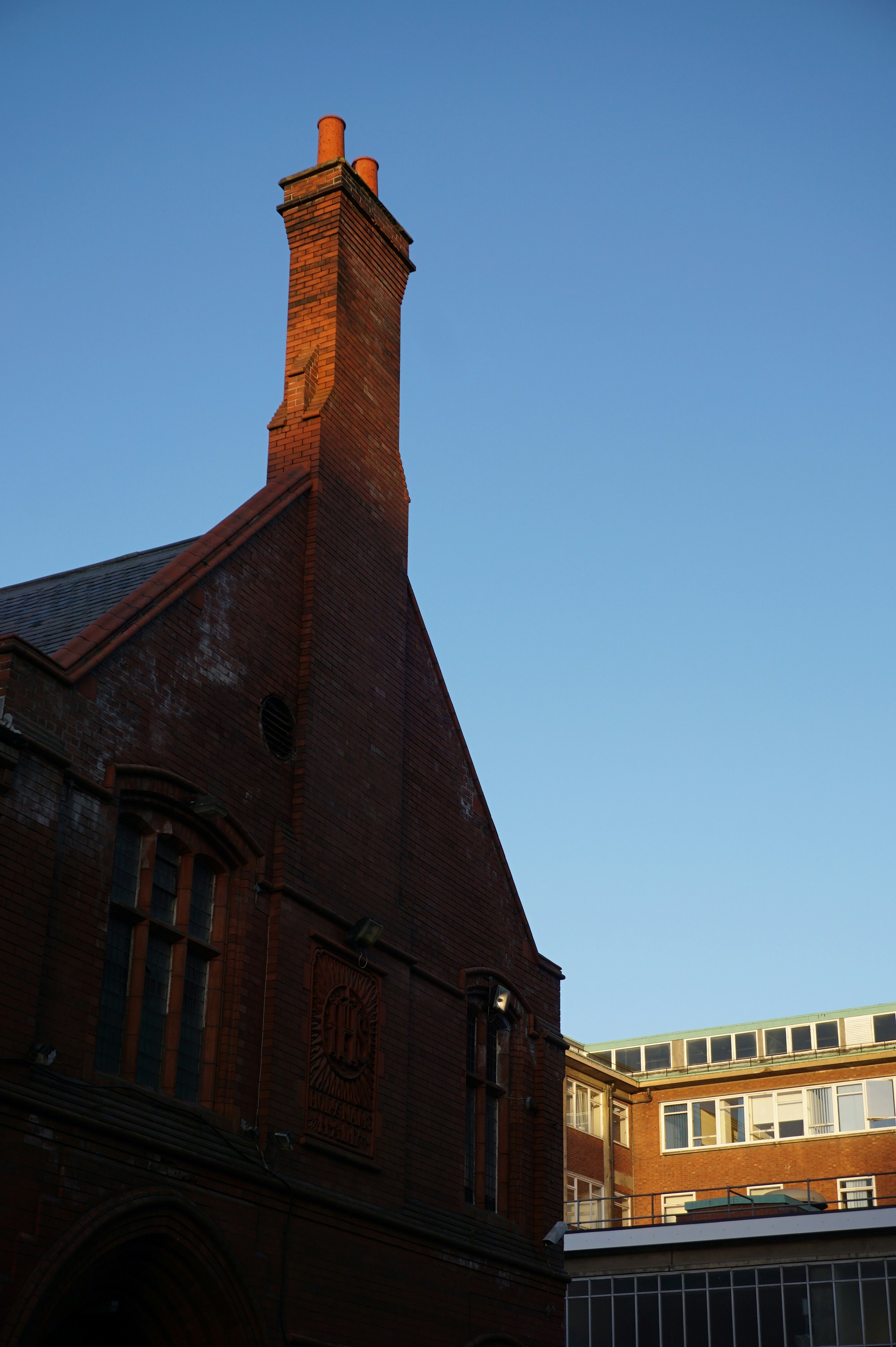 Brick Chimney against a Clear Sky: An Old Building Reaching for Daylight