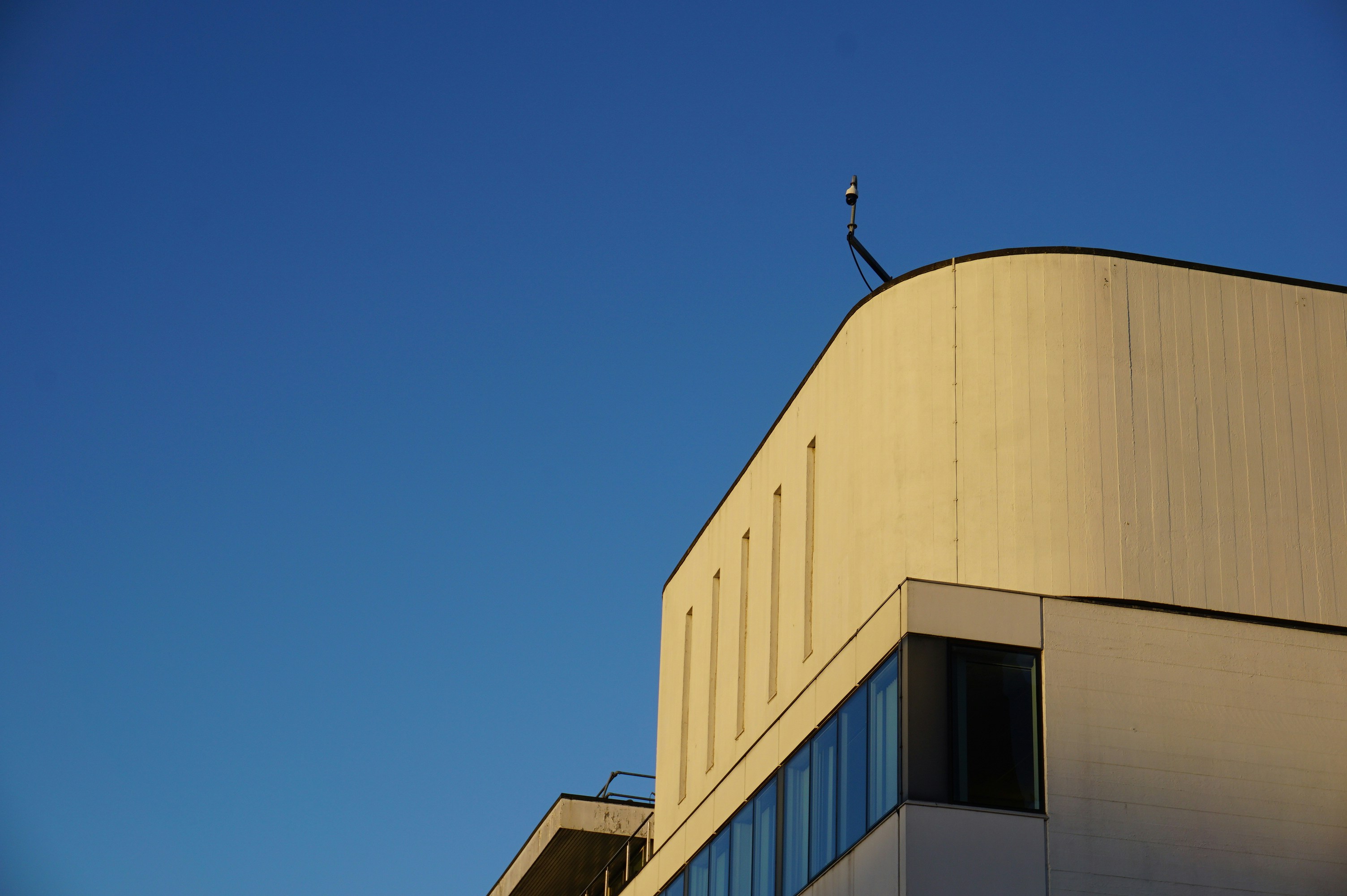 Cornered Light: A Clean Facade Beneath a Vast Sky