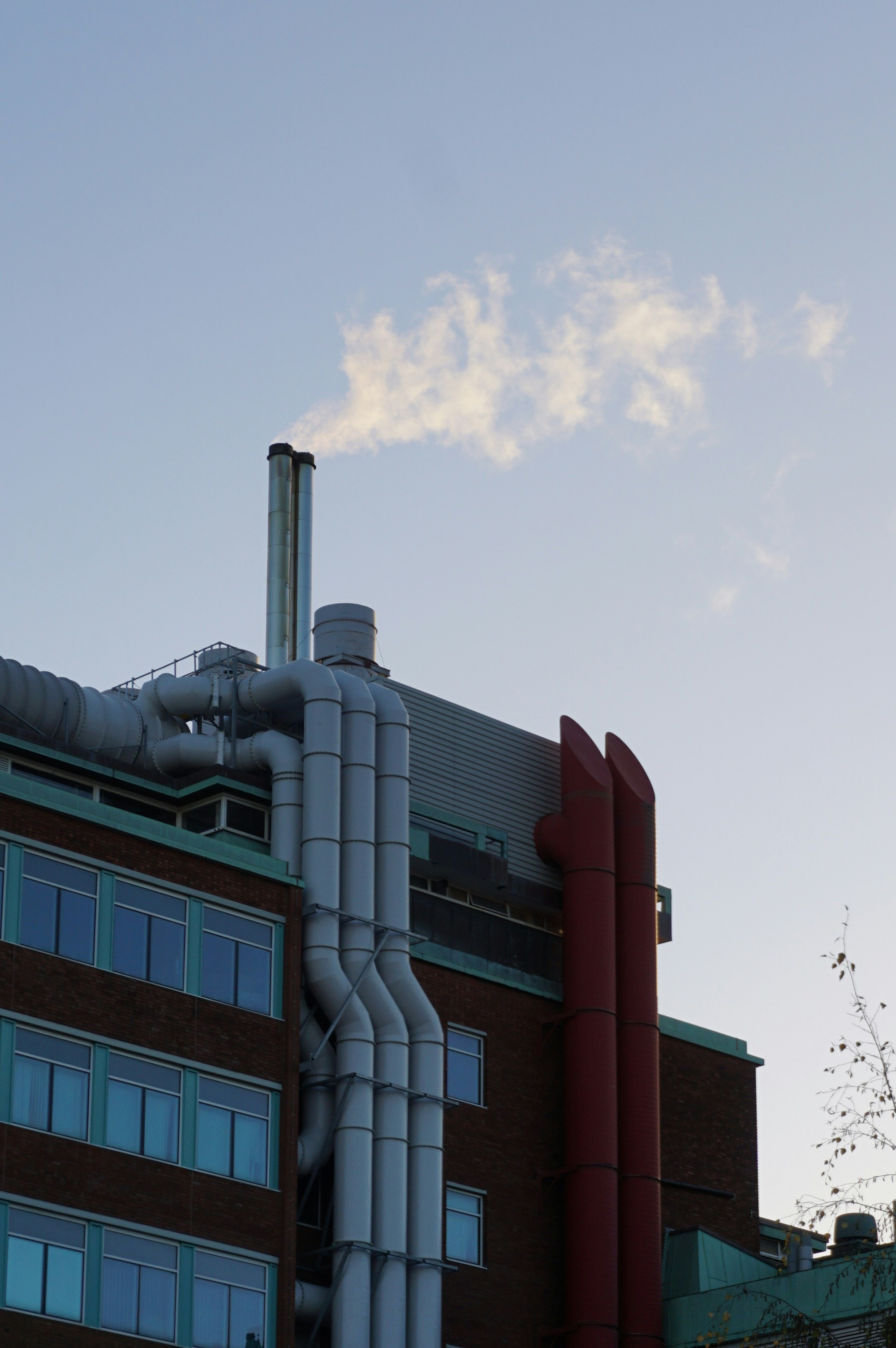 Industrial Skyline: Pipes and Chimney Silhouettes Against a Clear Sky