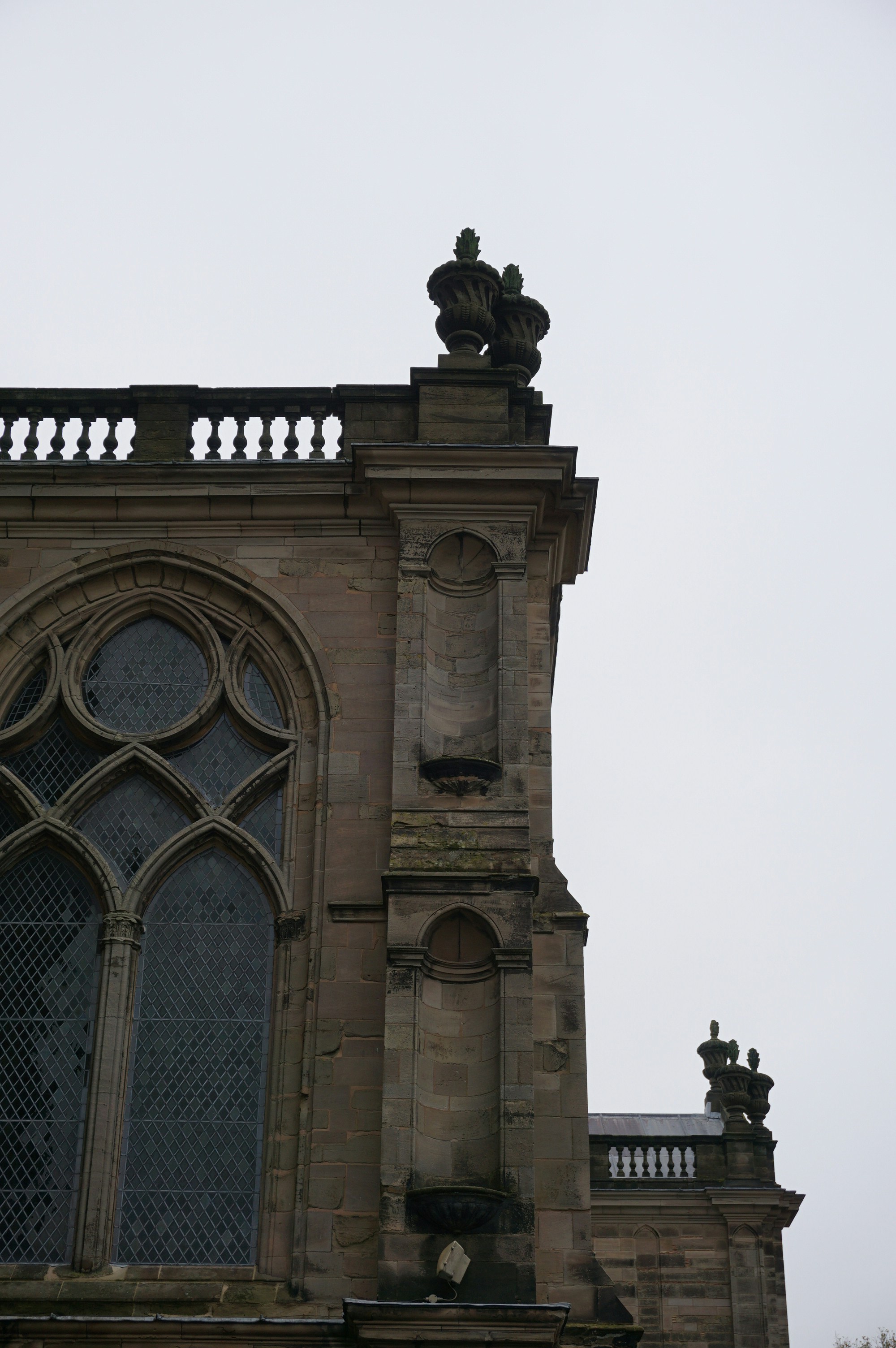 Gothic Cornerstone: Stone Facade and Crowned Turrets Against a Pale Sky