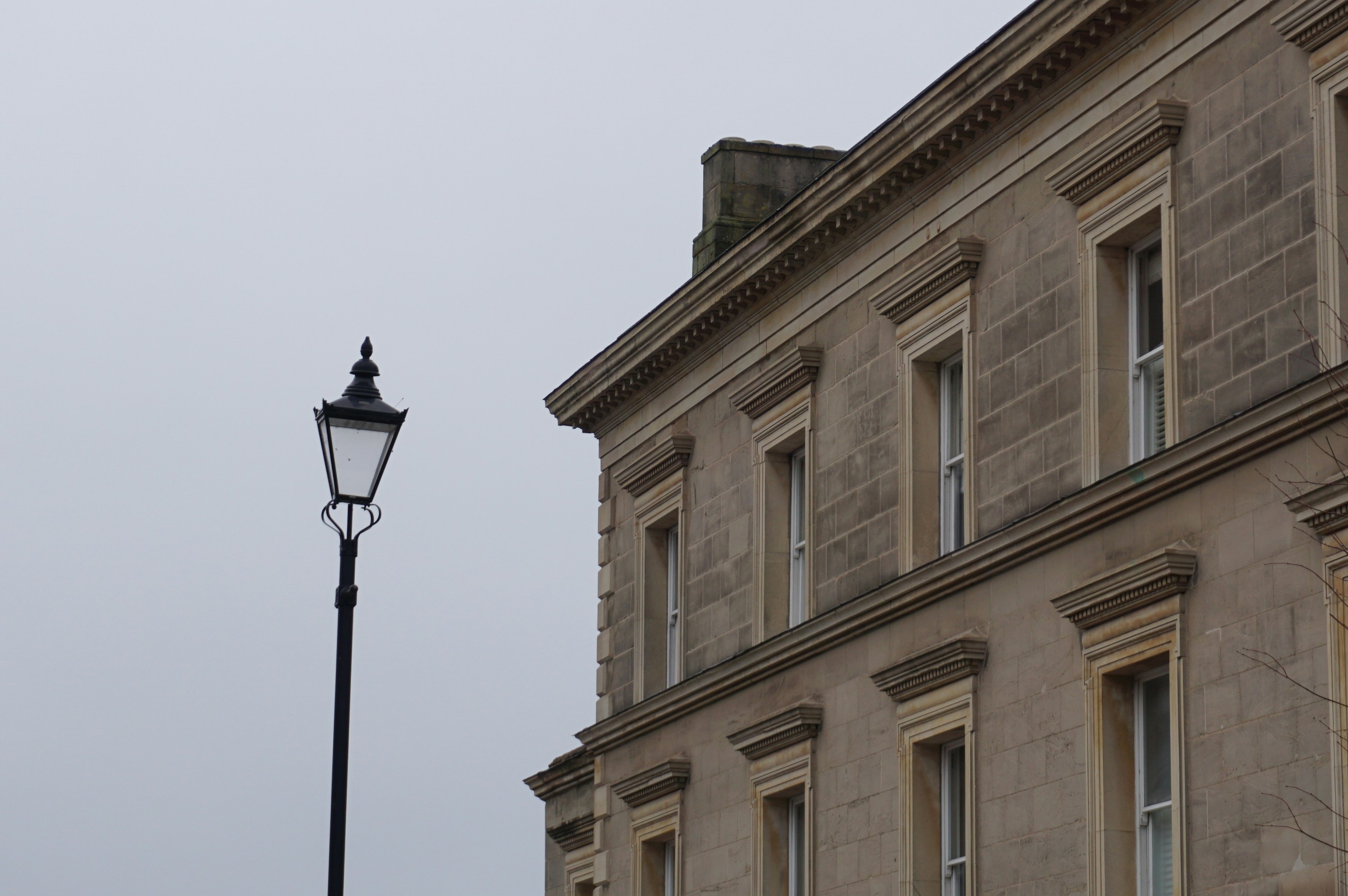 Lamppost and Corner Facade: An Archway of Stone and Shadows