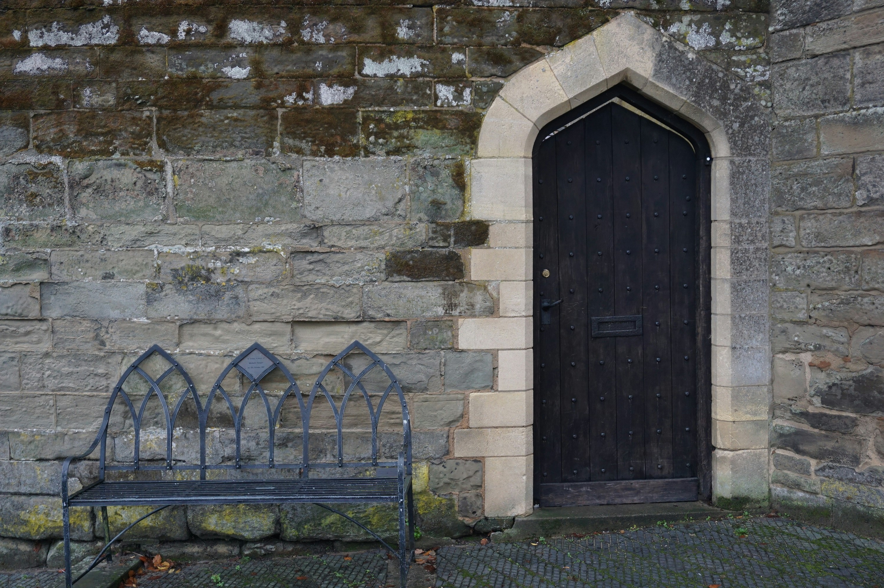 Stone Wall, Dark Doorway, and Wrought-Iron Bench