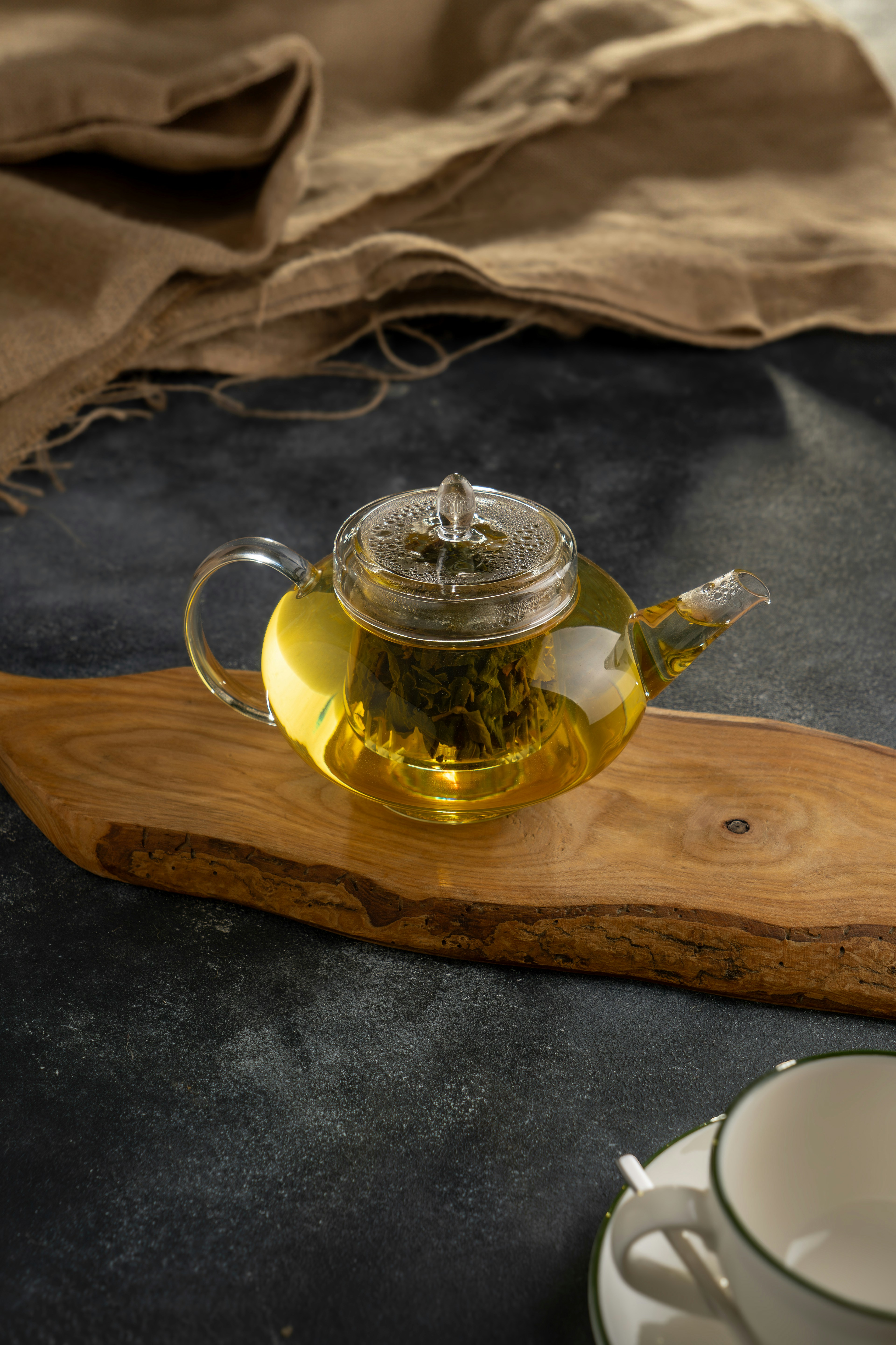 Glass Teapot on a Wooden Platform: Golden Brew Under Soft Studio Light
