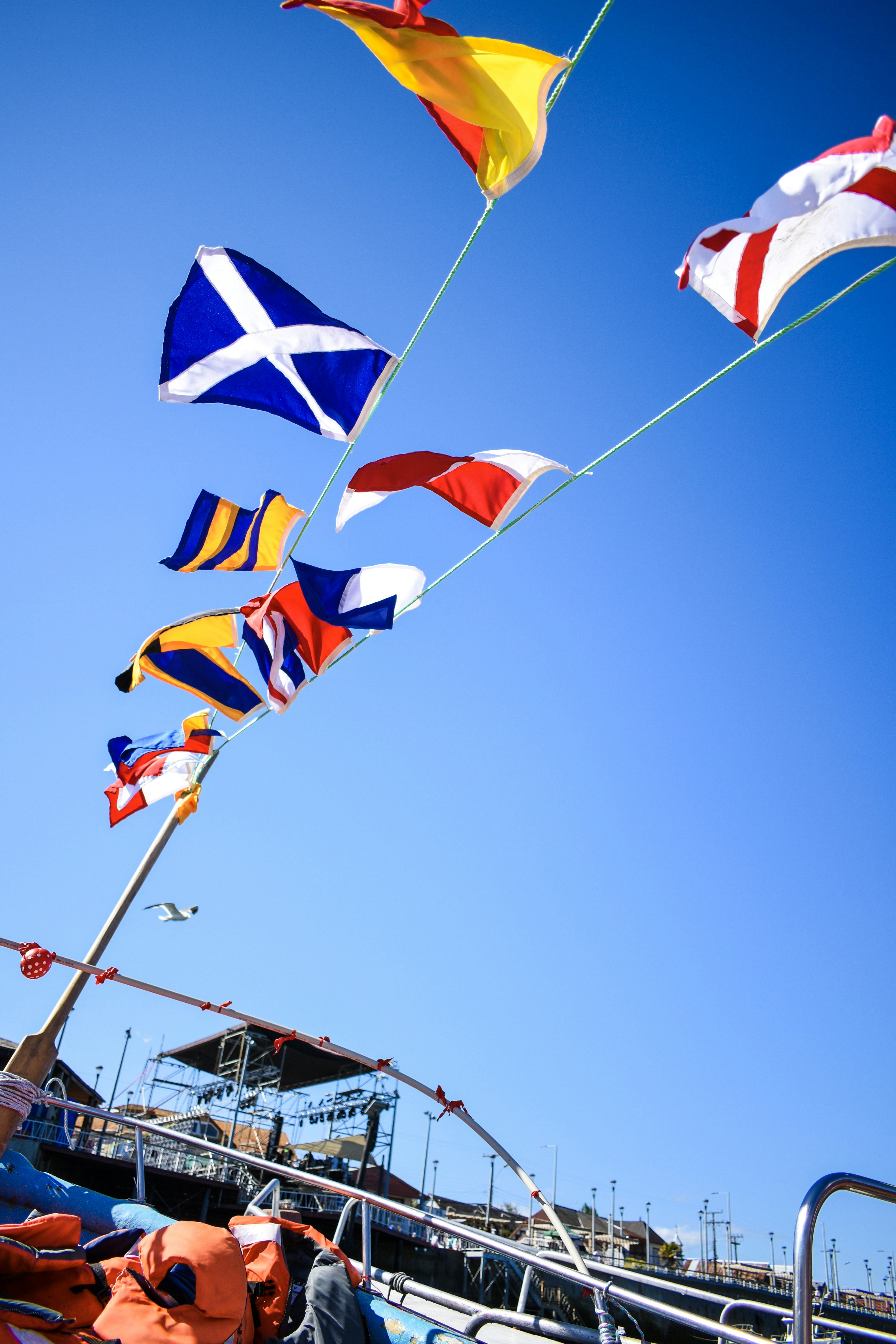 Sailing Signals: Colorful Flags Against a Clear Sea-Blue Sky