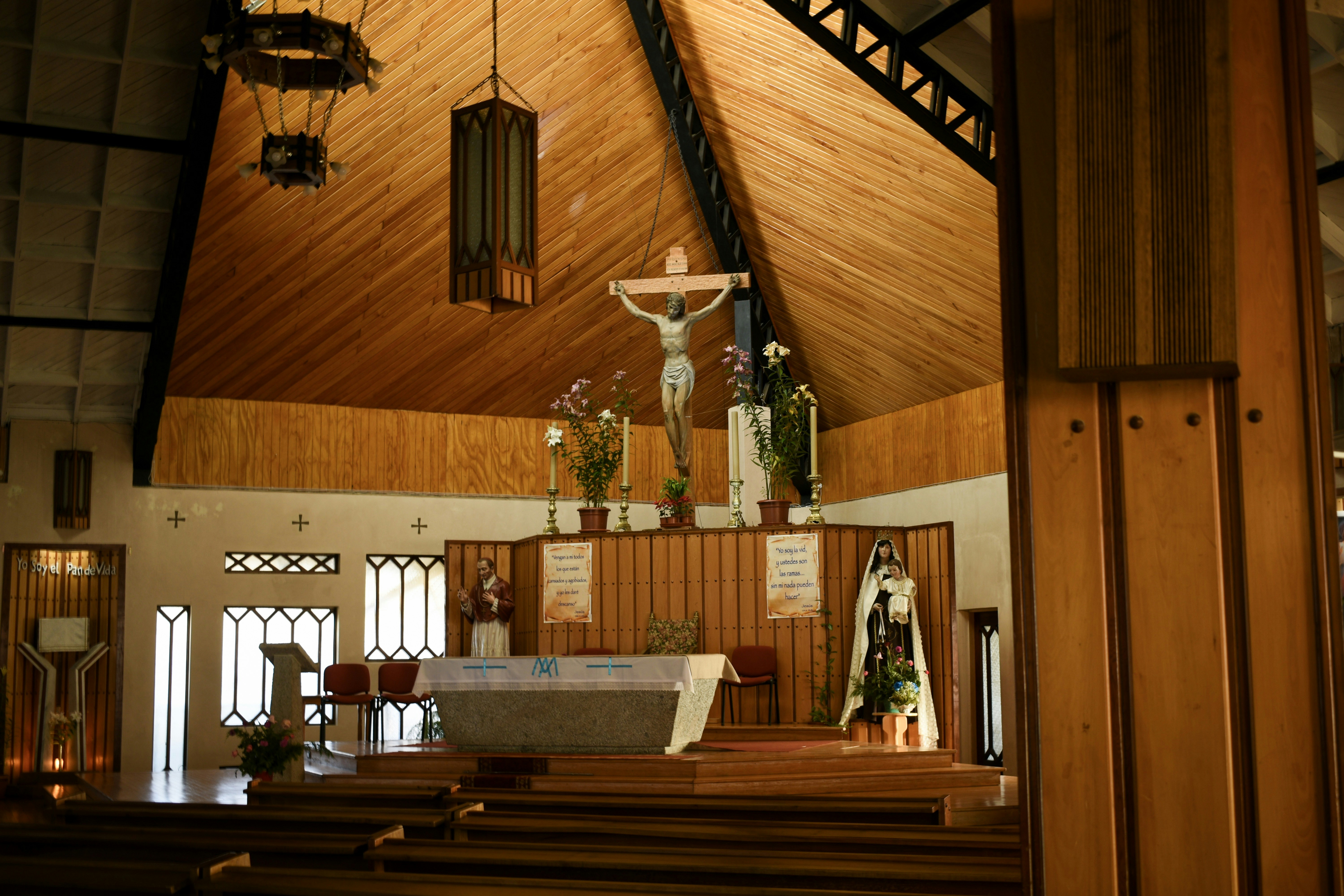 Cruciform Quiet: A Church Altar Framed by Cedar Rails and Stained Glass Light