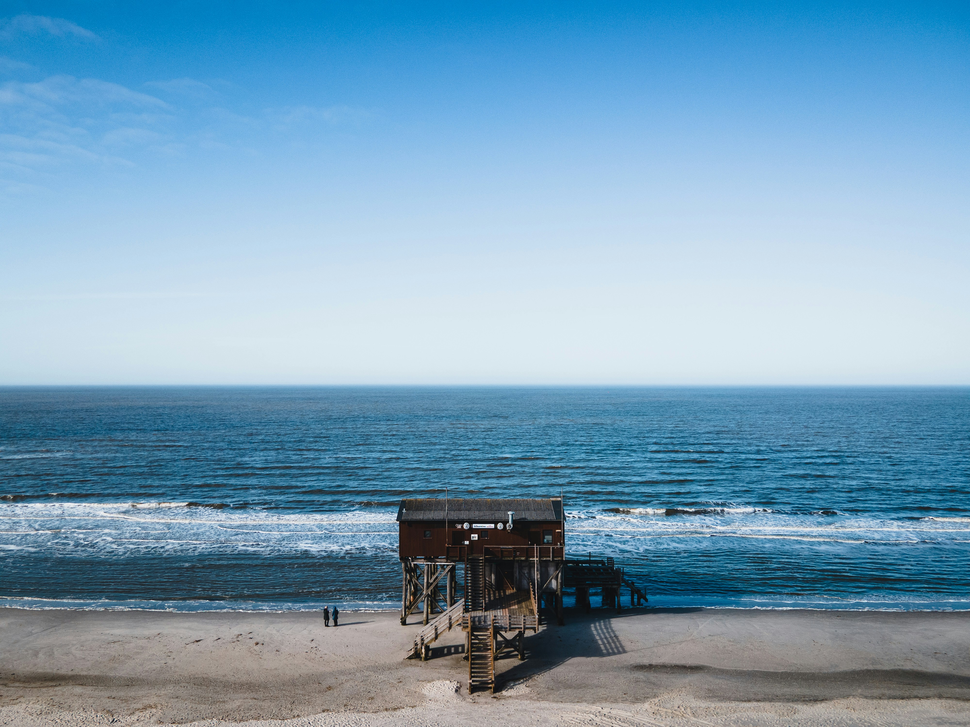 A lone lifeguard shack at the edge of a quiet shoreline