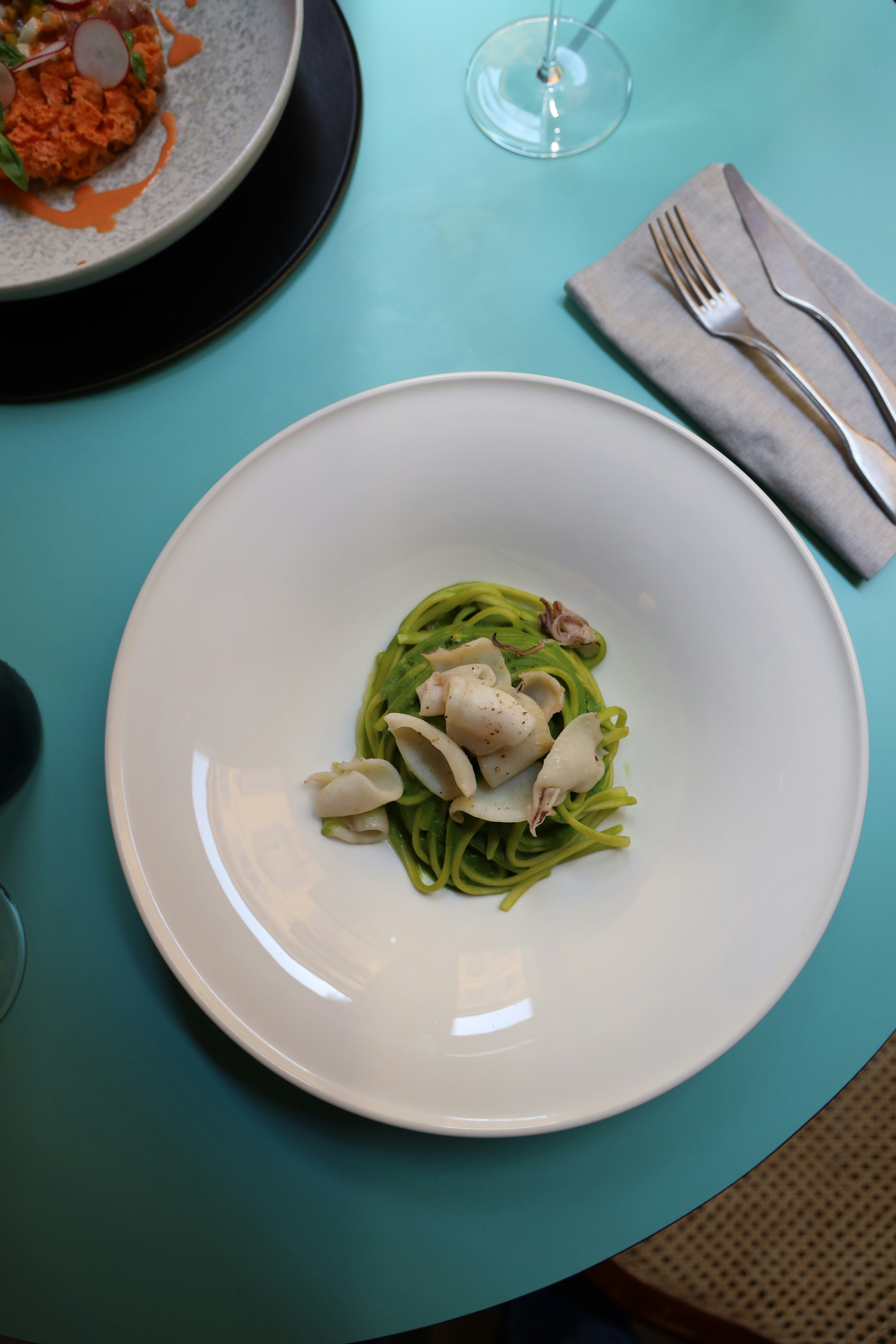 Pastel Tabletop: Green Pasta Spotlight at a Delicate Table