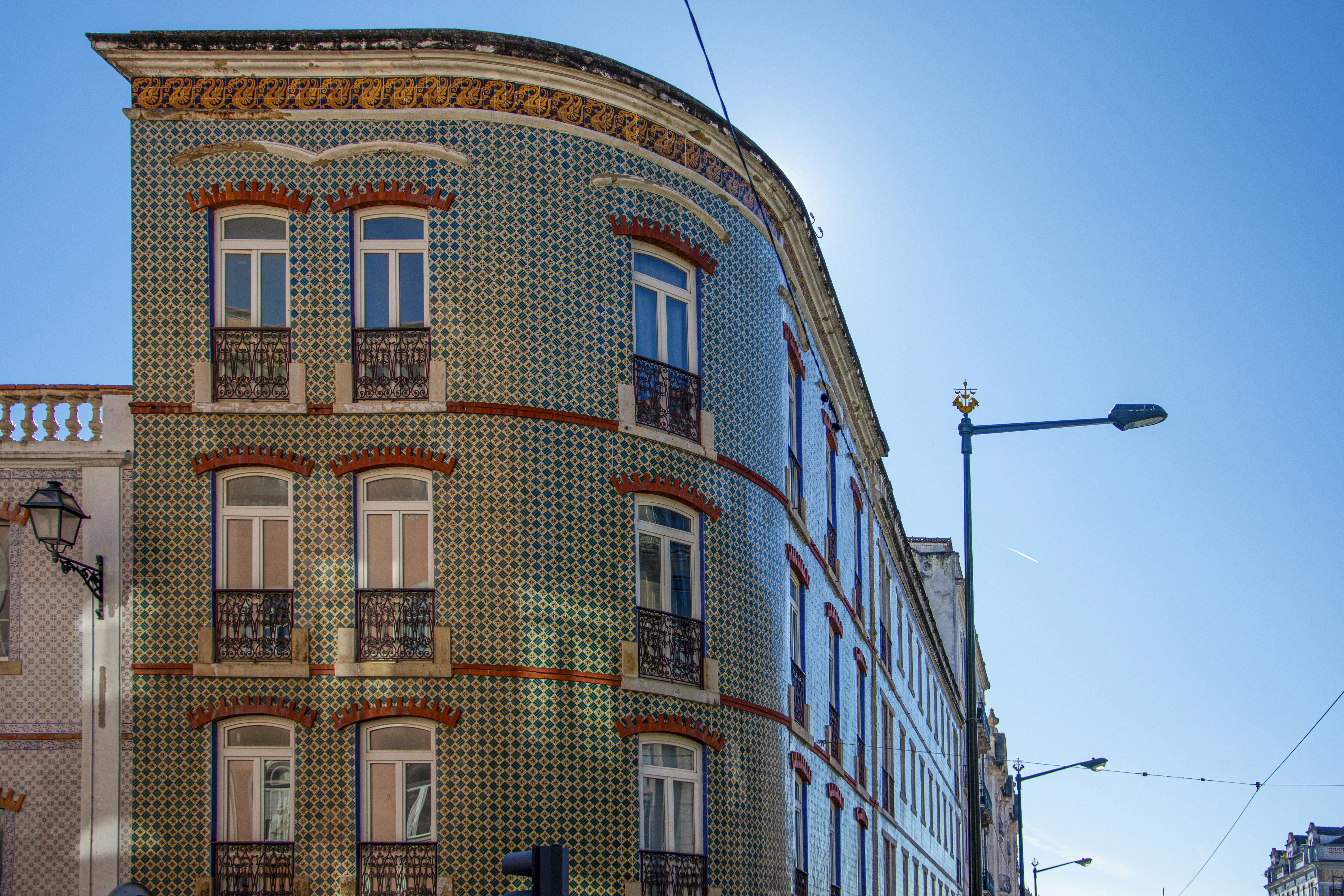 Colorful tiled facade curving into a sunlit city street