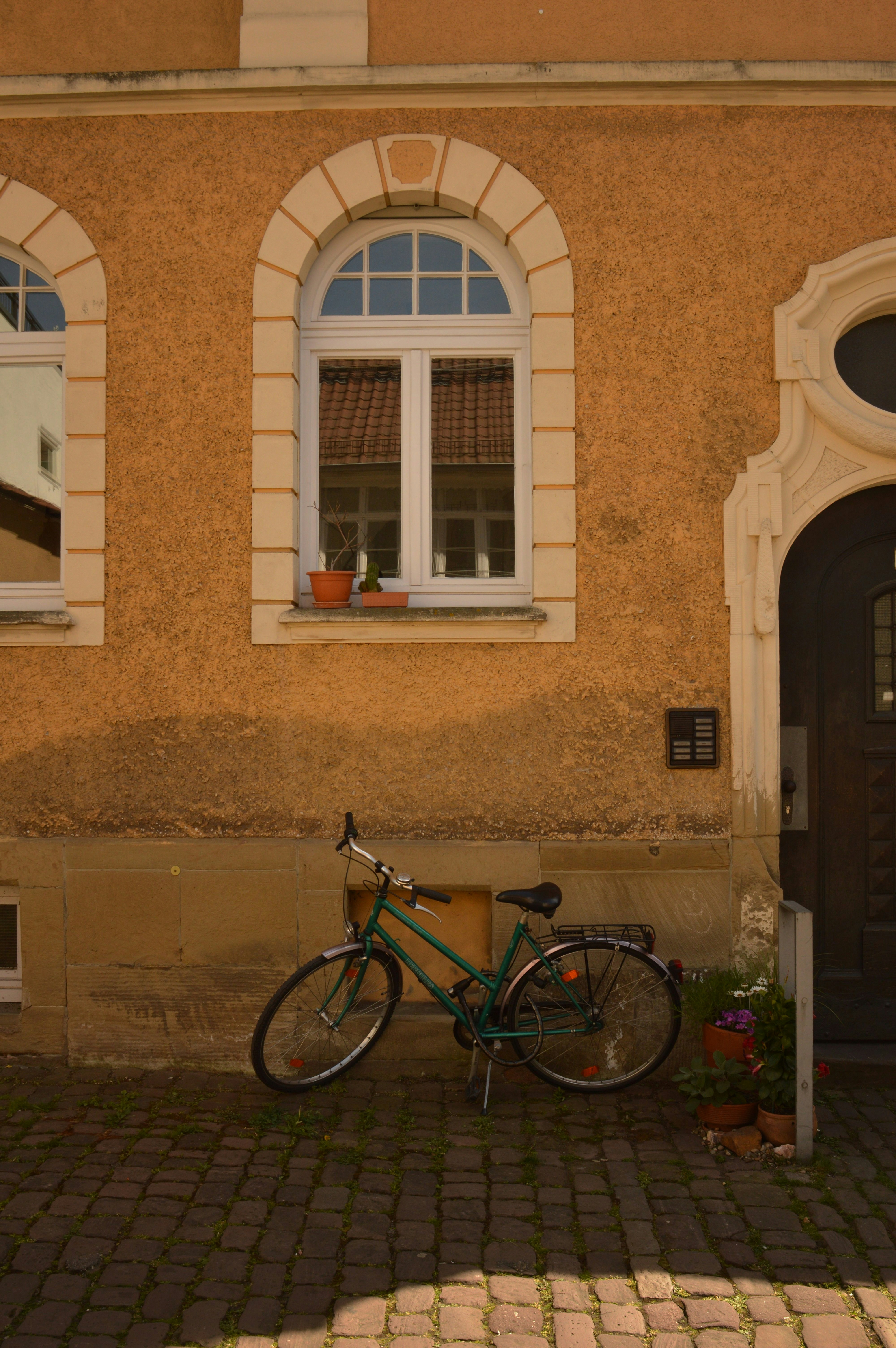 Sunlit Orange Facade with Green Bicycle