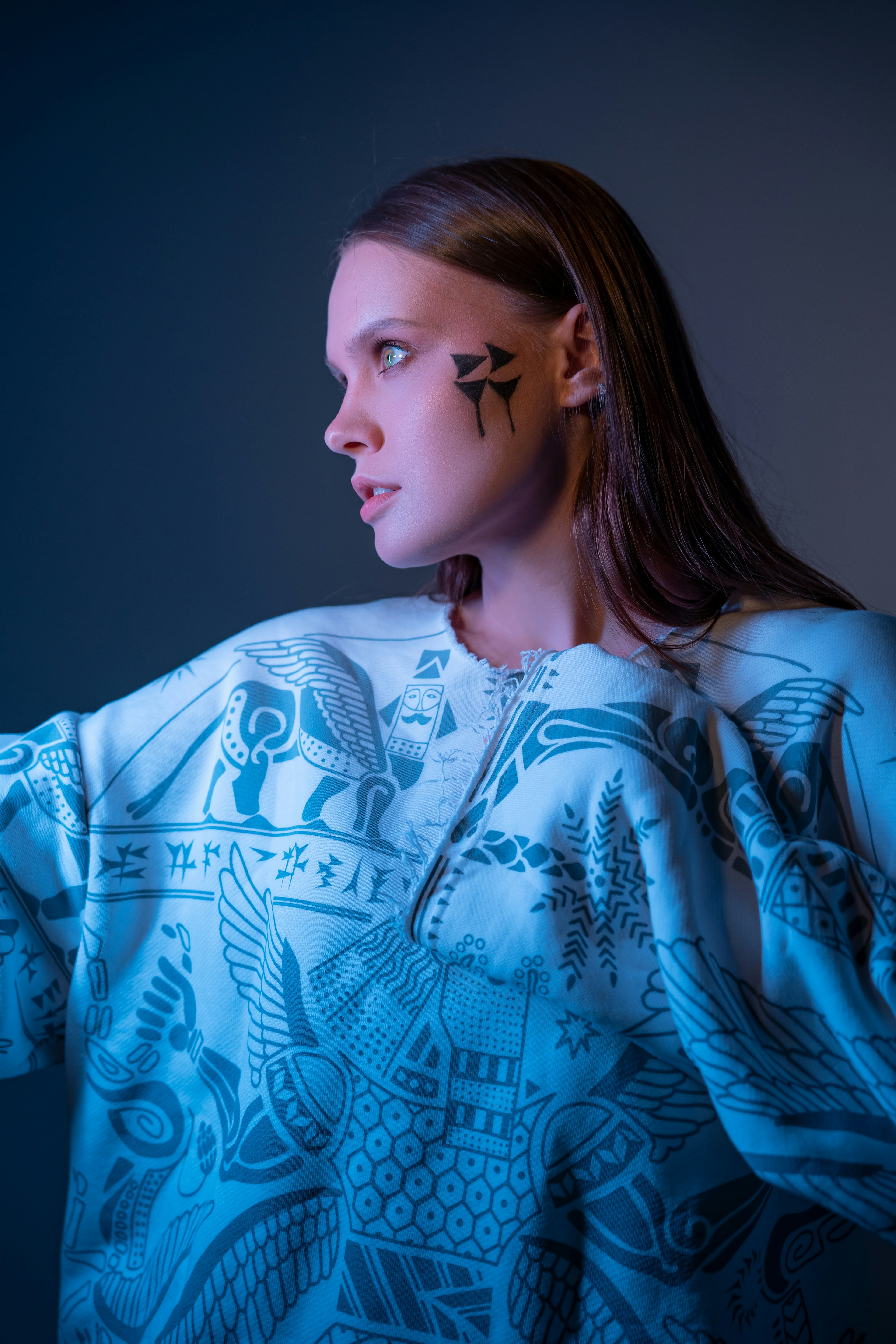 Profile in Blue: Tattooed Stare and Patterned Cloak