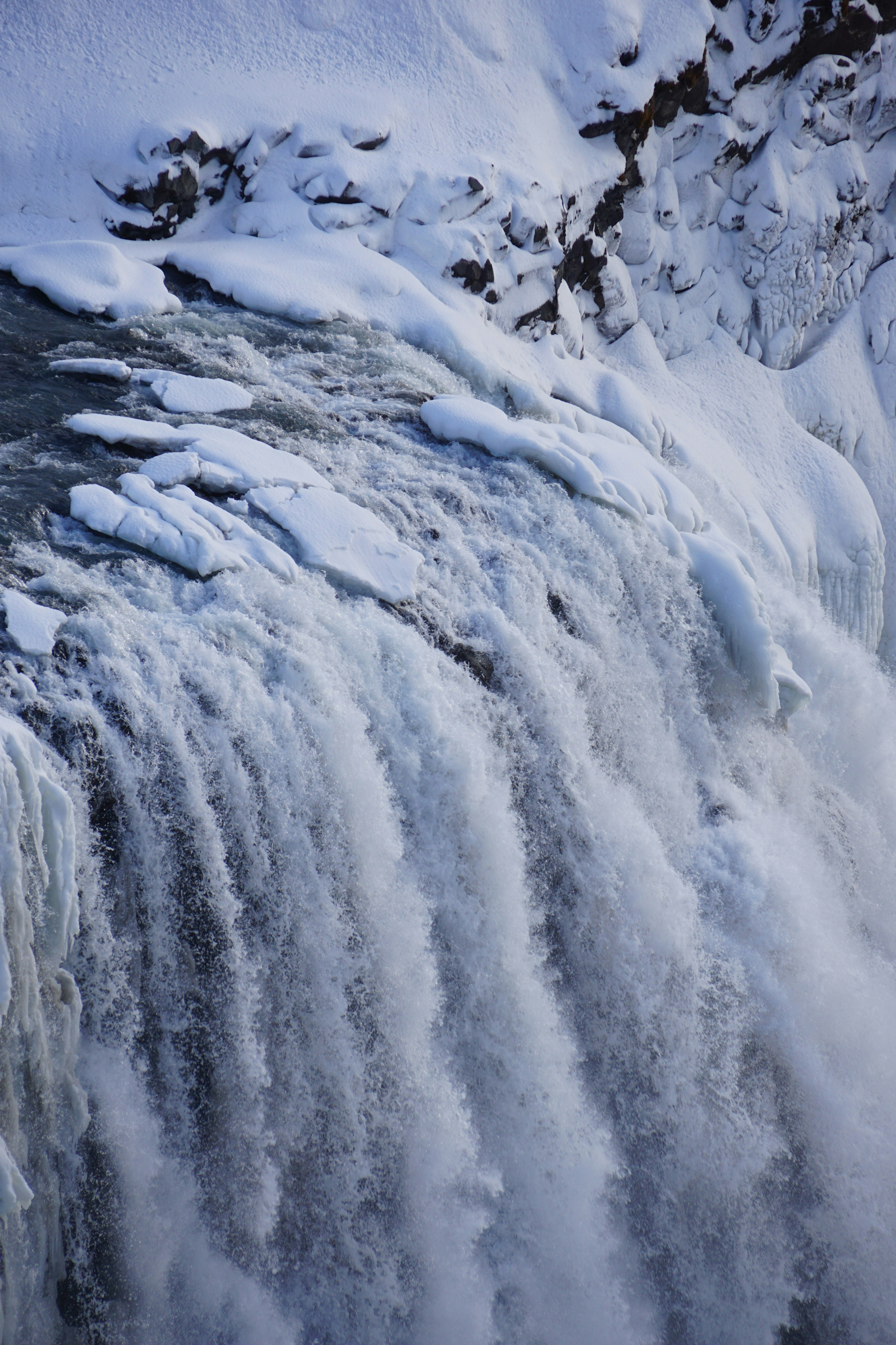 Icy Veil: A Frozen Cascade unfurls against snowbound cliffs