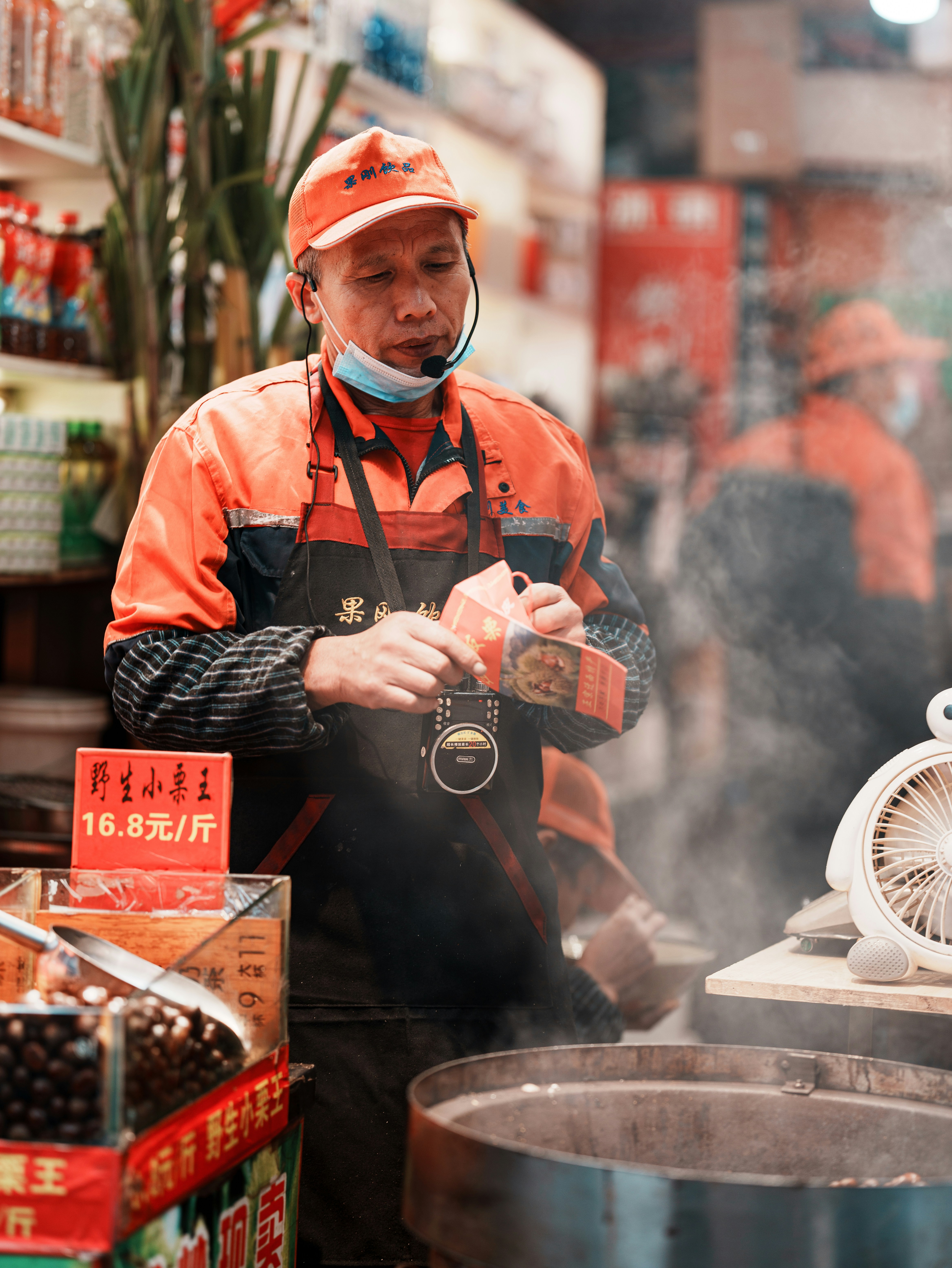 Steam and Sale: A Vendor in Orange Keeps the Customer in Focus